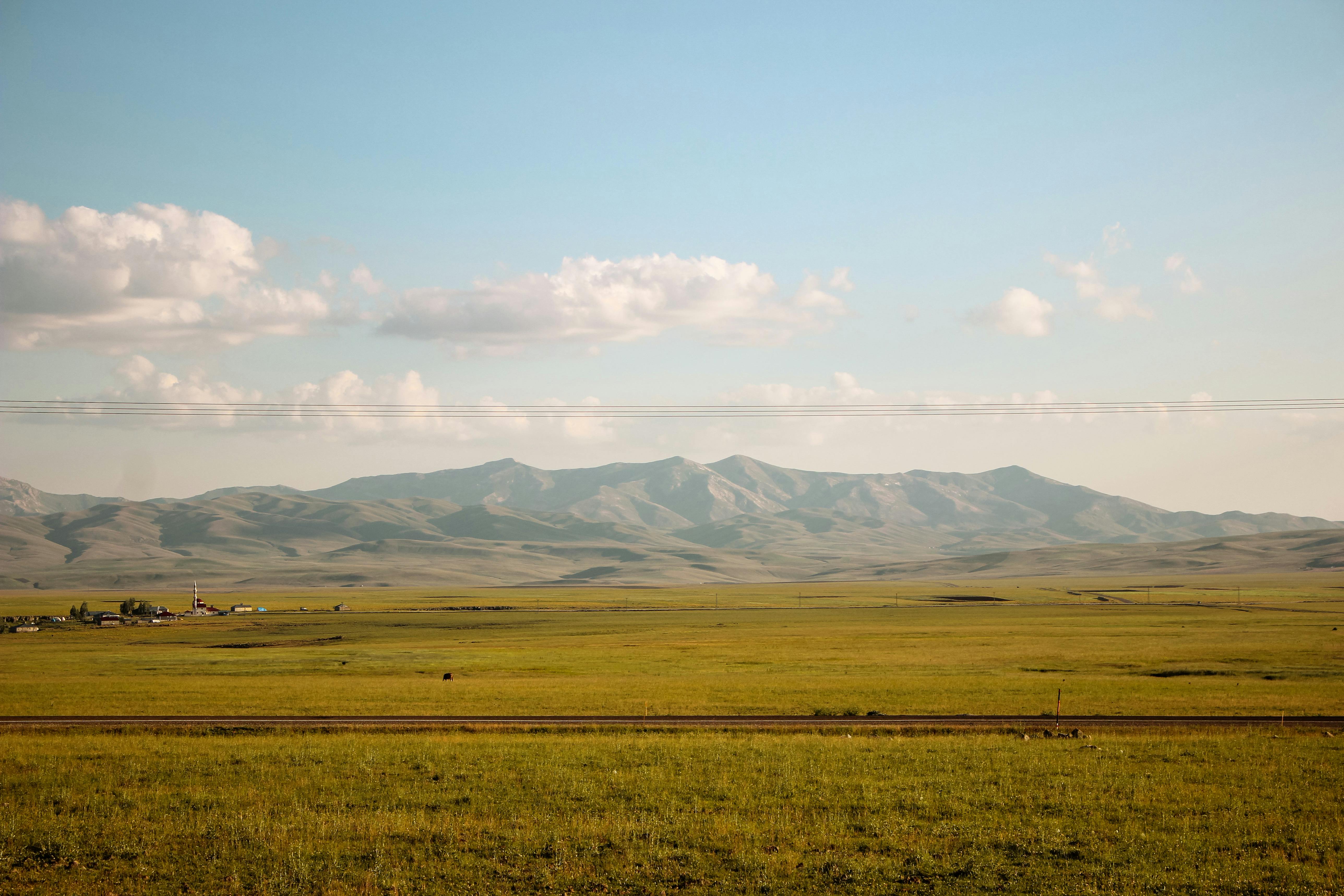 Landscape of a Flat Grass Field and Mountains in the Horizon · Free ...