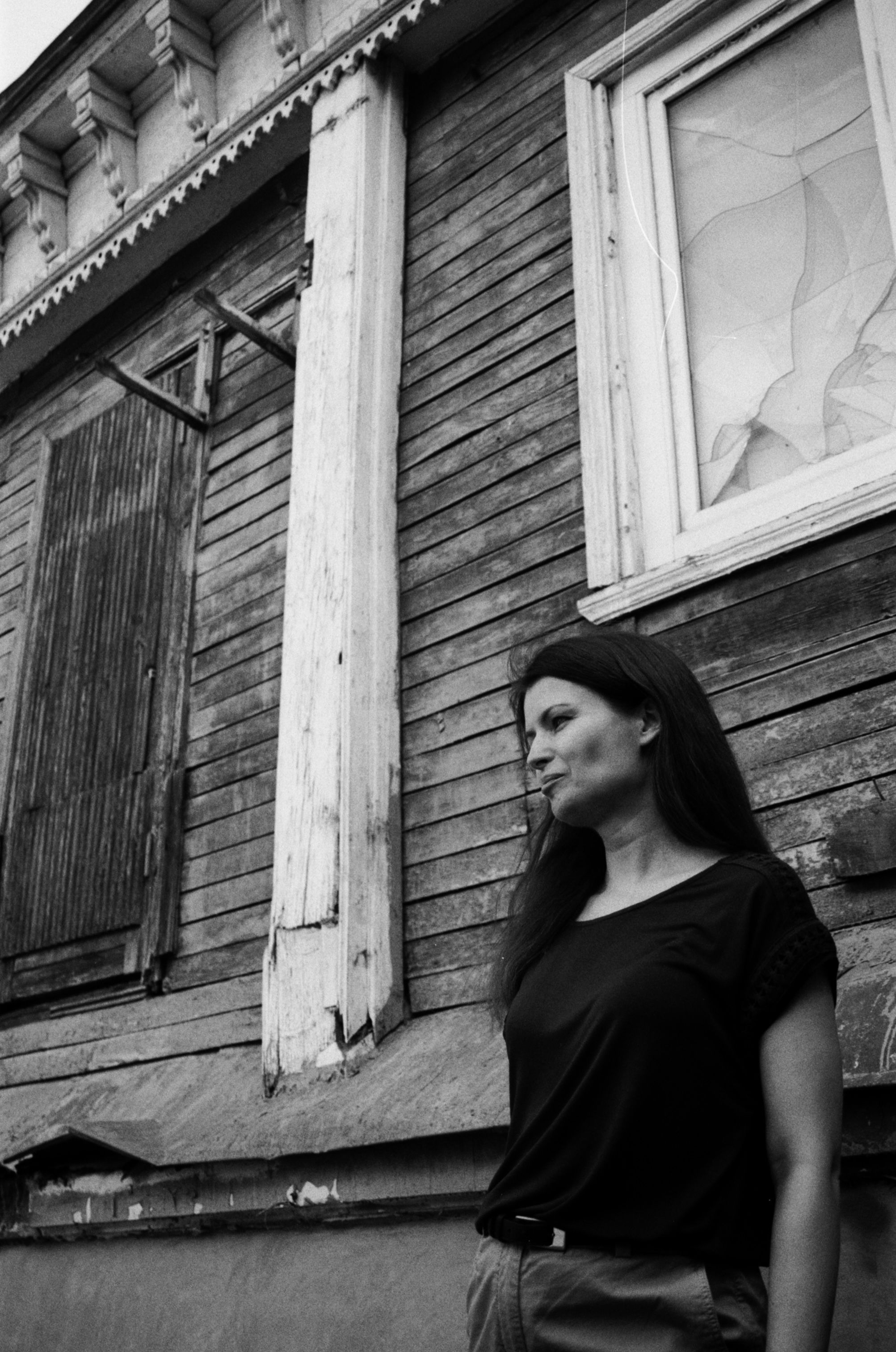 Brunette Woman in Black Blouse Posing by an Abandoned Wooden House ...
