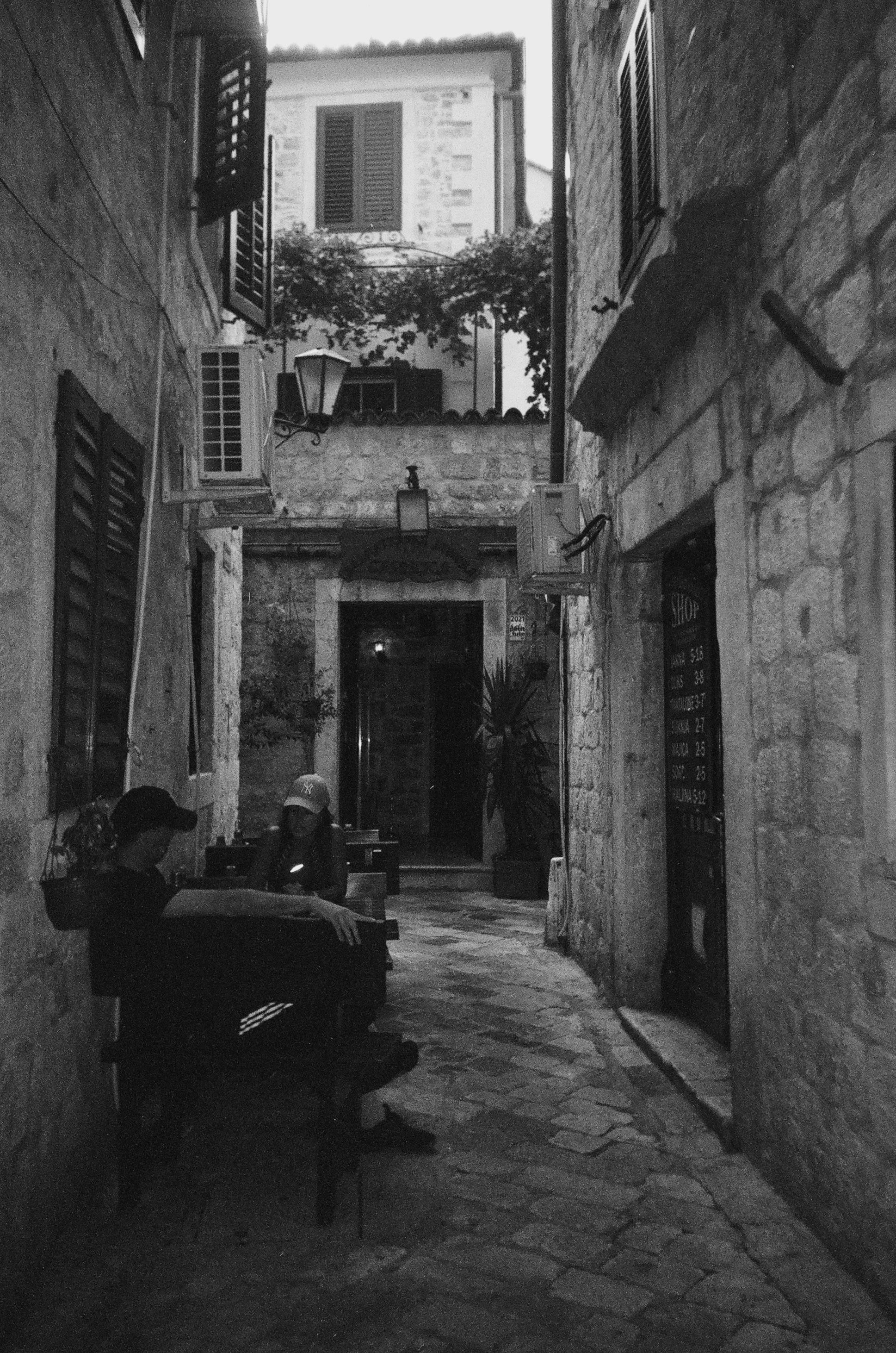 Black and White Photo of People Sitting by Outdoor Cafe Tables in ...
