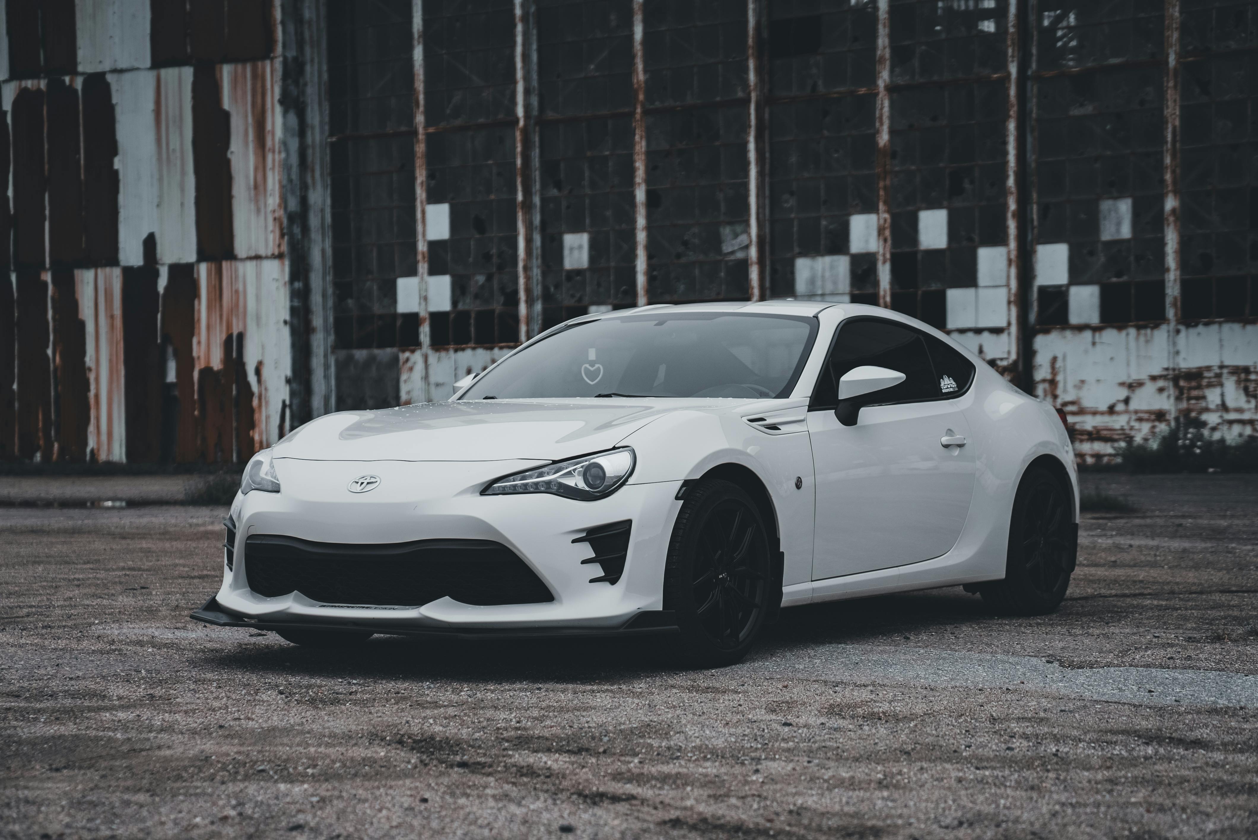 A White Toyota GT86 in front of an Abandoned Warehouse · Free Stock Photo