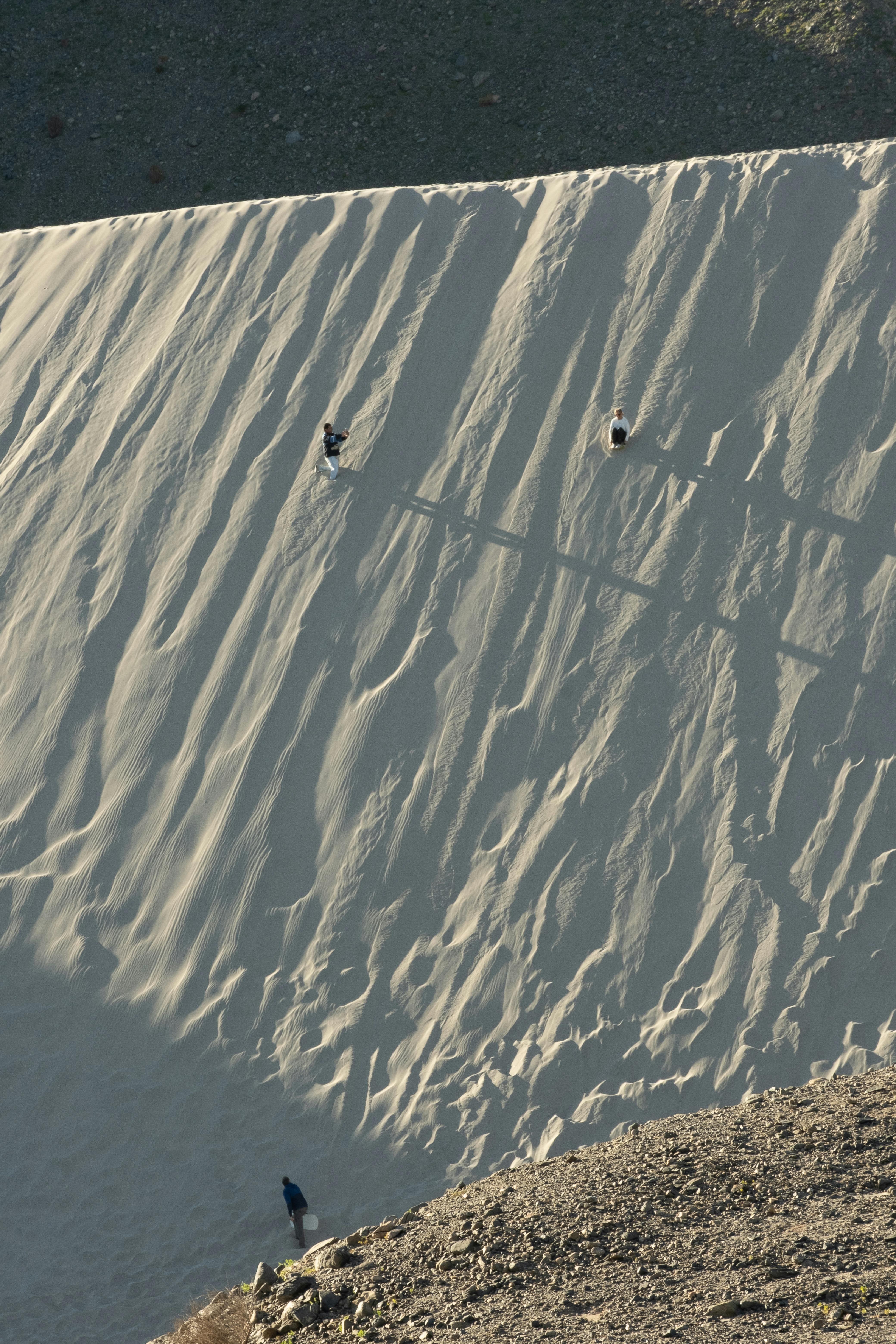 People Sliding Down a Steep Snowy Hill · Free Stock Photo