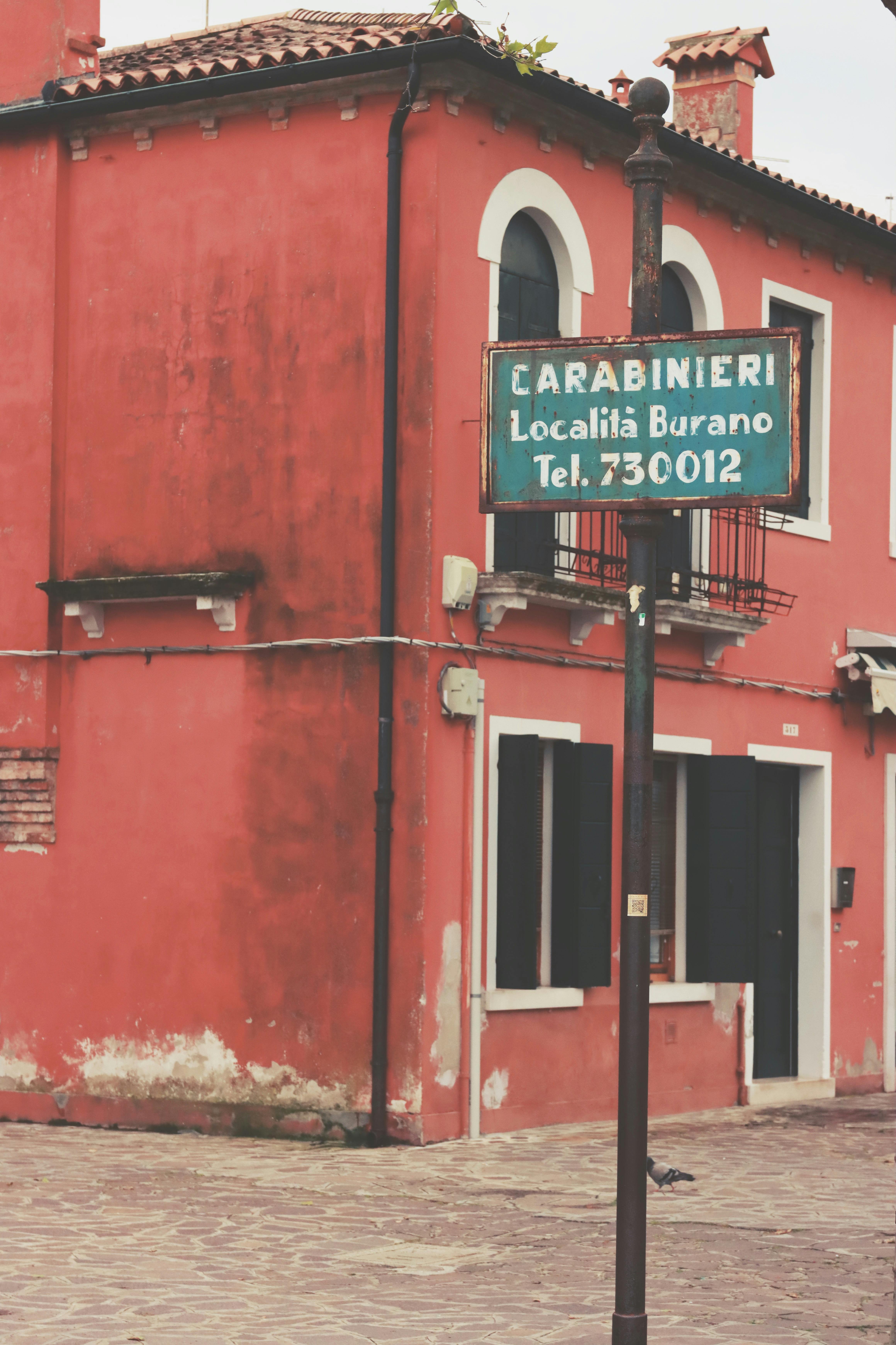 View of a Sign in front of a Red Building · Free Stock Photo