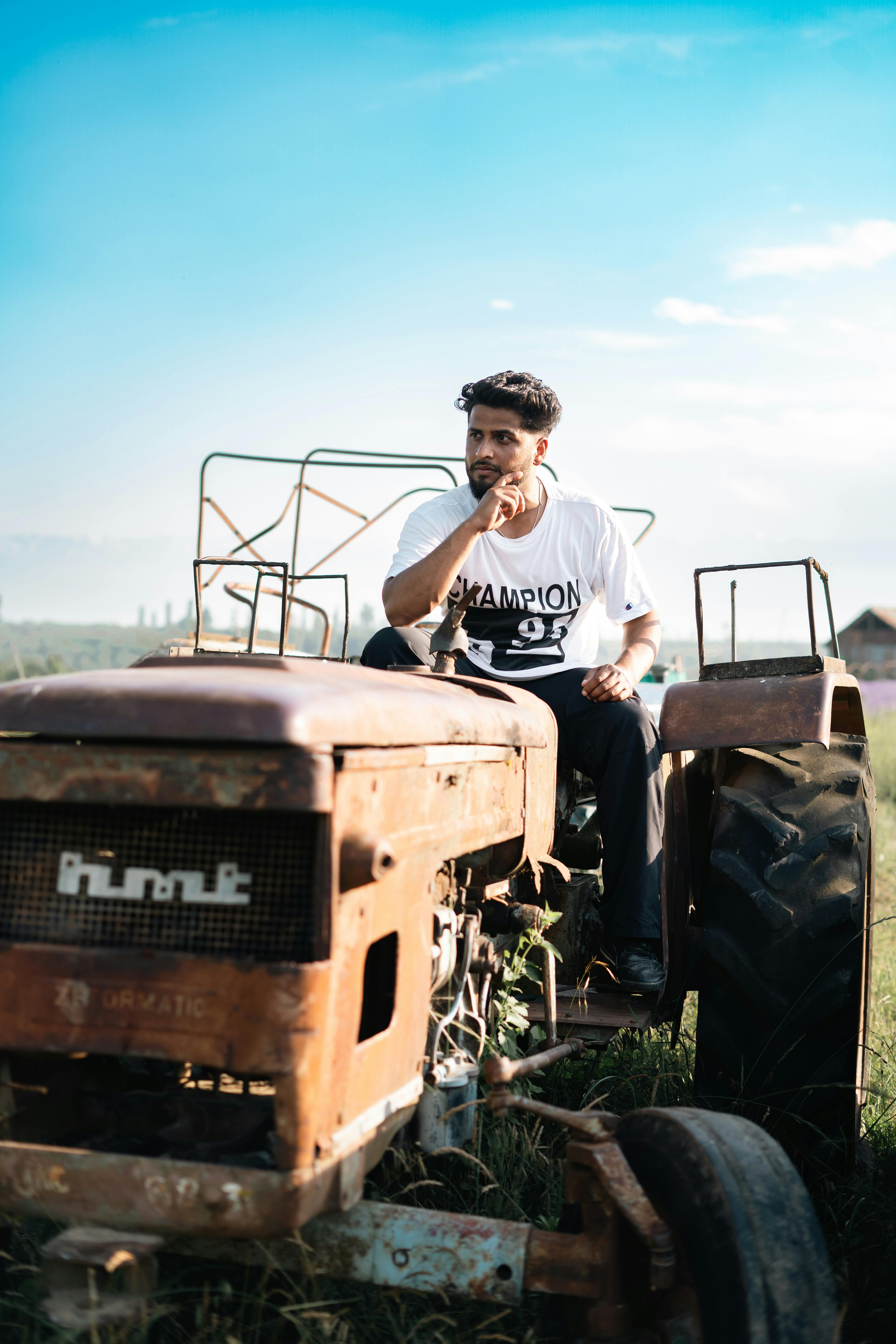 Man Sitting on Rusty Tractor · Free Stock Photo