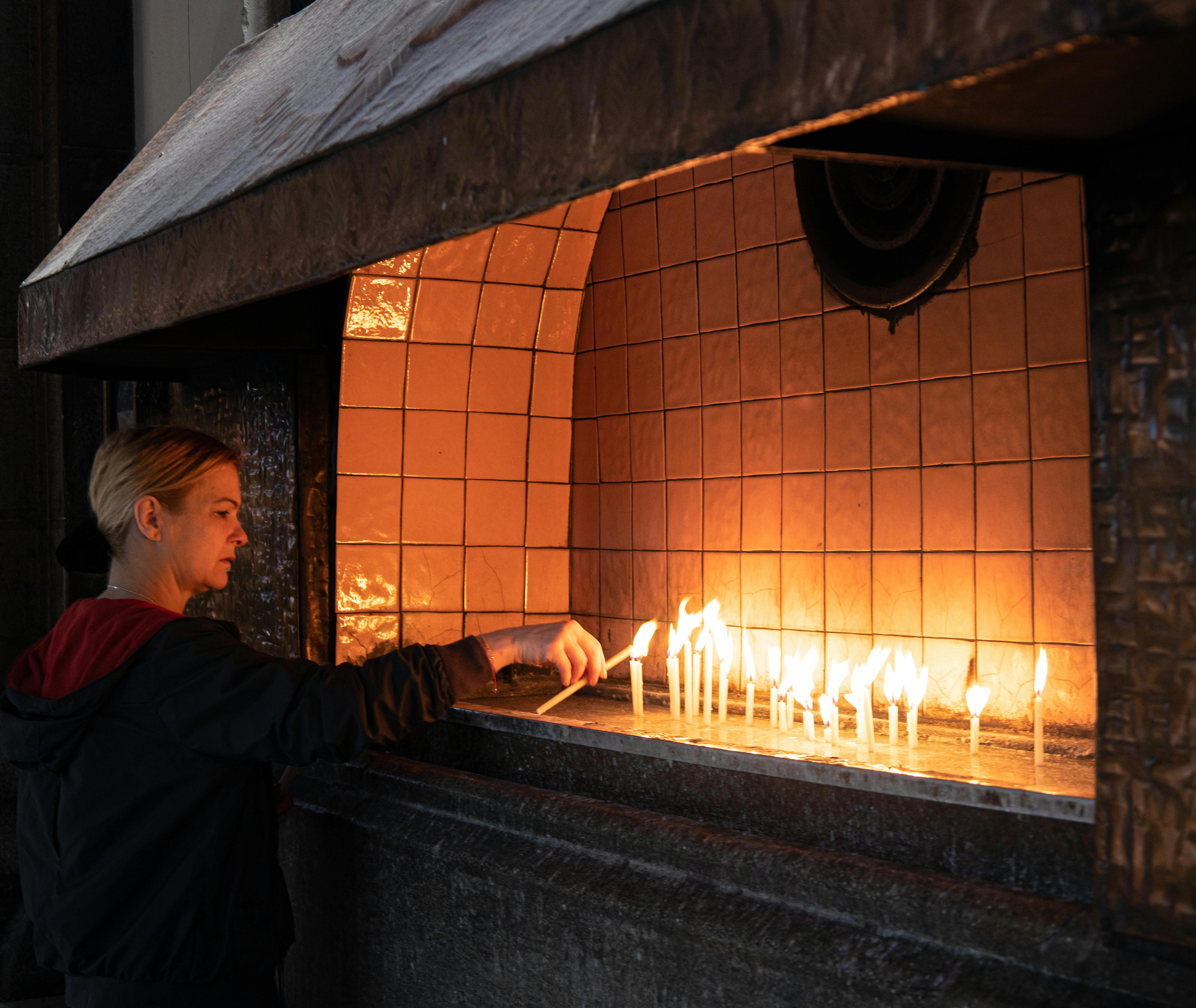 Woman Lighting Religious Offering Candle · Free Stock Photo