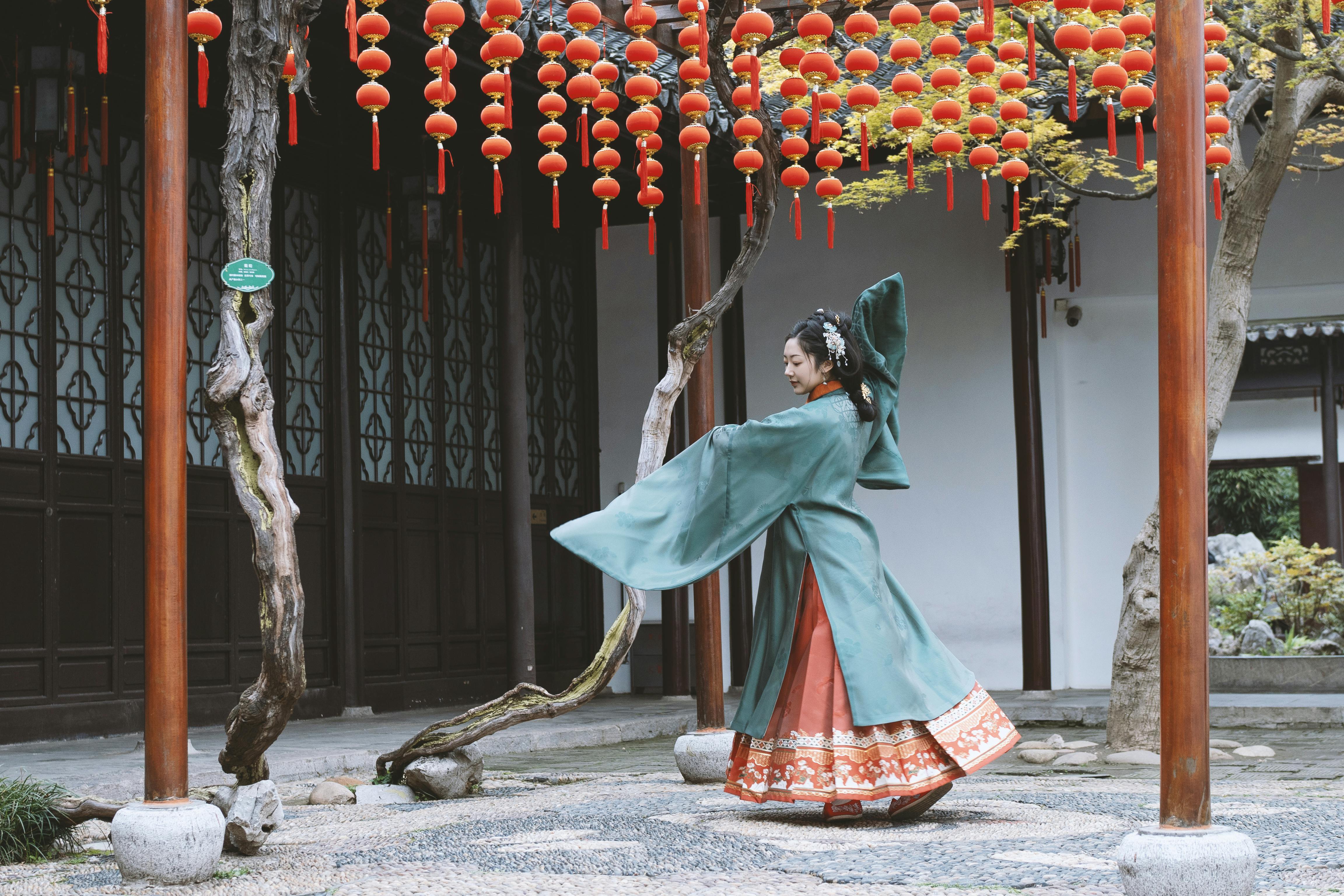 Young Woman Wearing a Traditional Hanfu Dress Dancing in a Garden ...