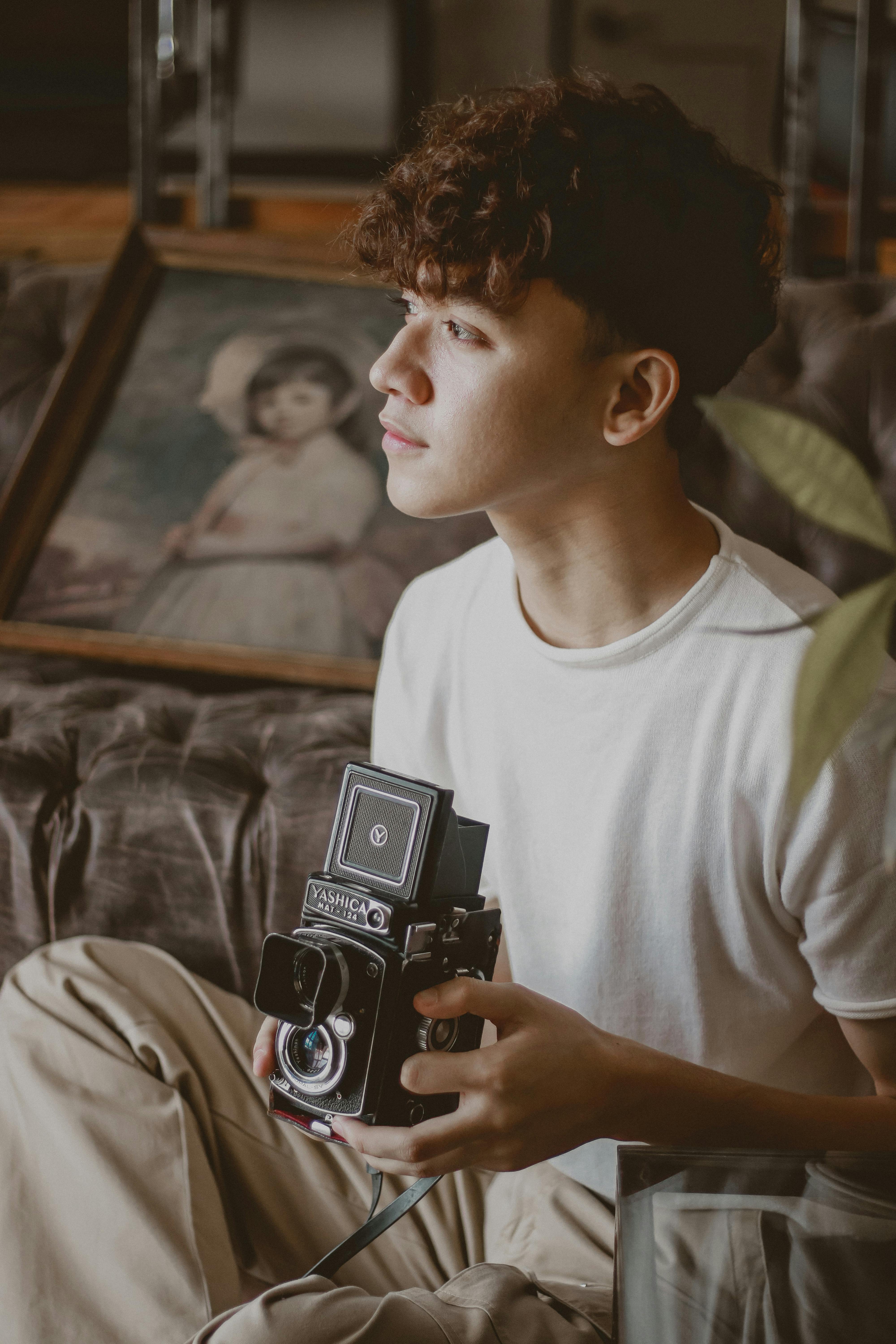 Man Sitting and Holding Vintage Camera · Free Stock Photo