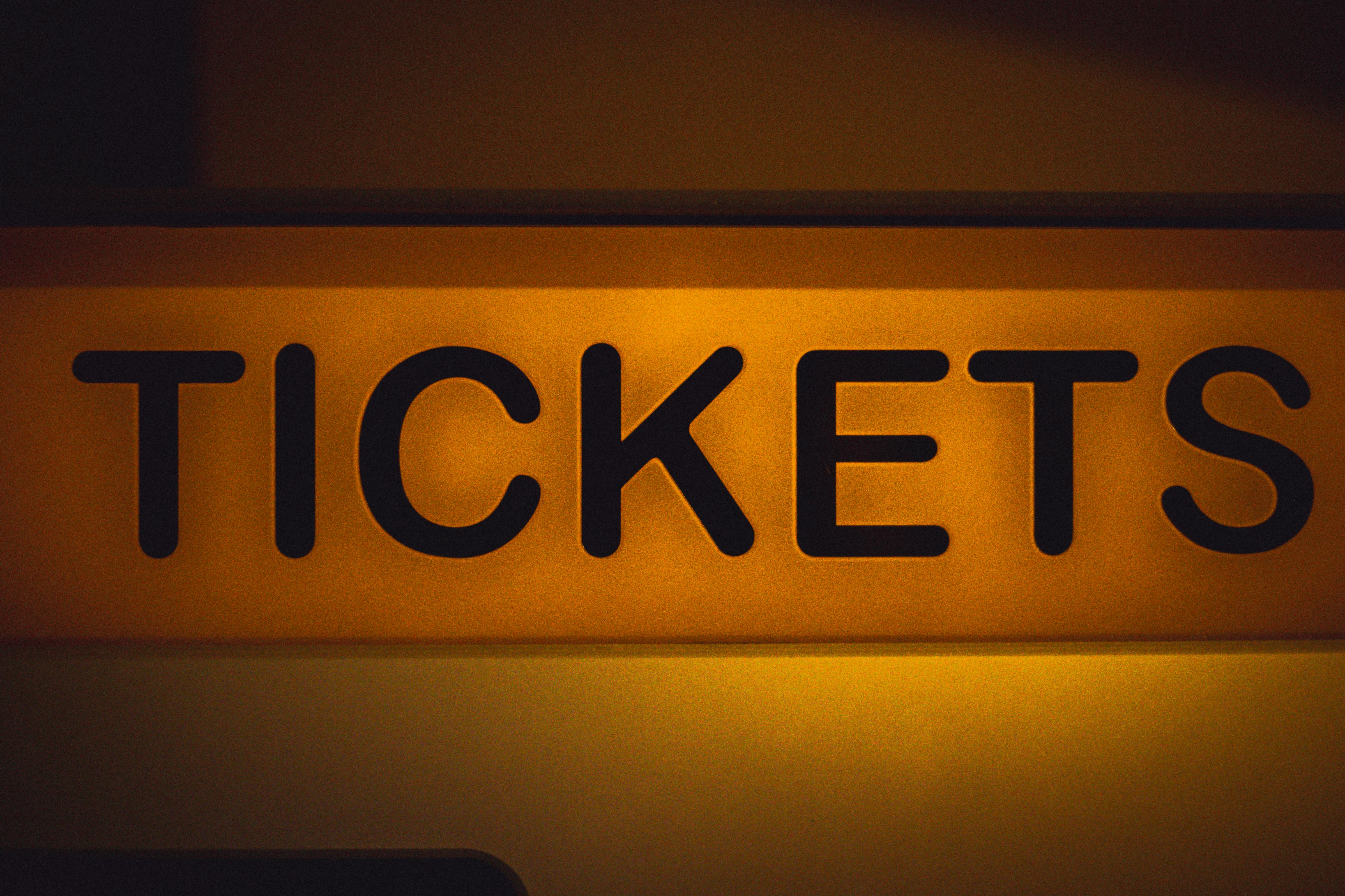 Tickets Text on Yellow Wall · Free Stock Photo