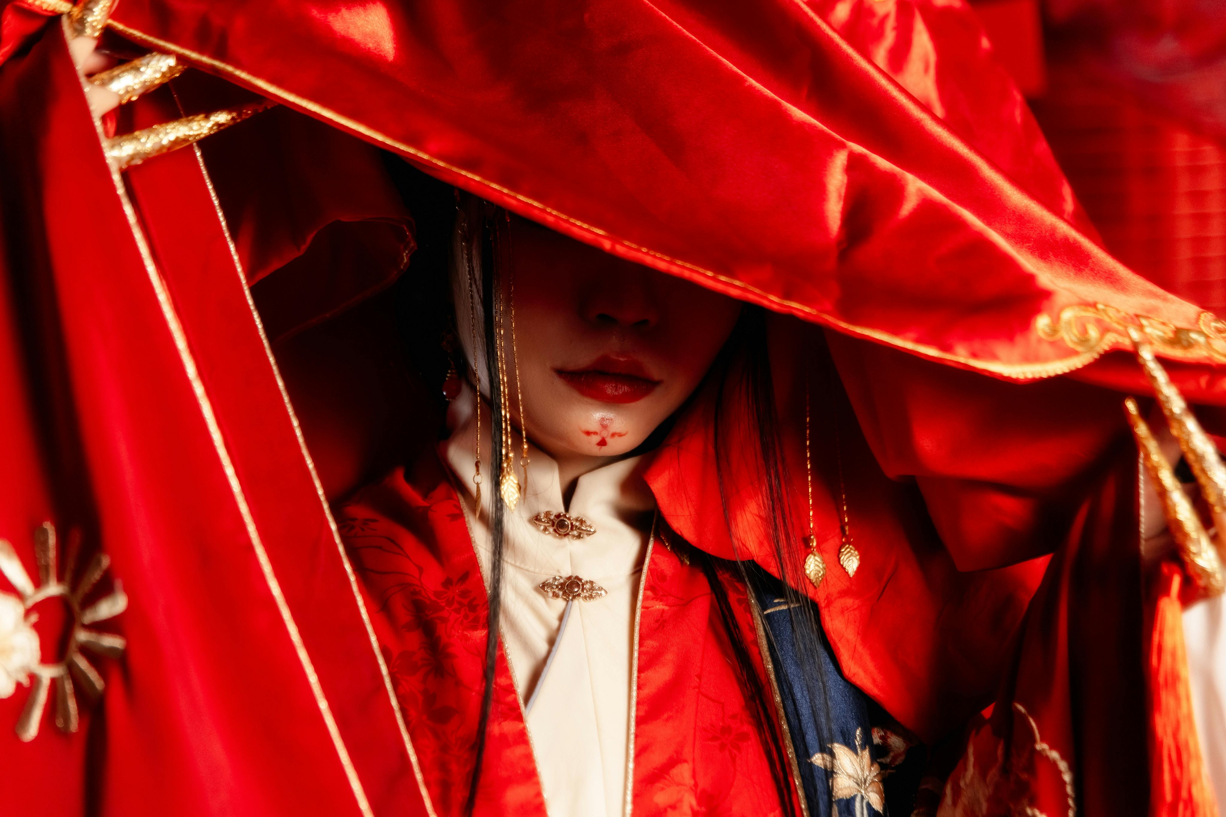 Woman Holding Red, Traditional Clothing over Face · Free Stock Photo