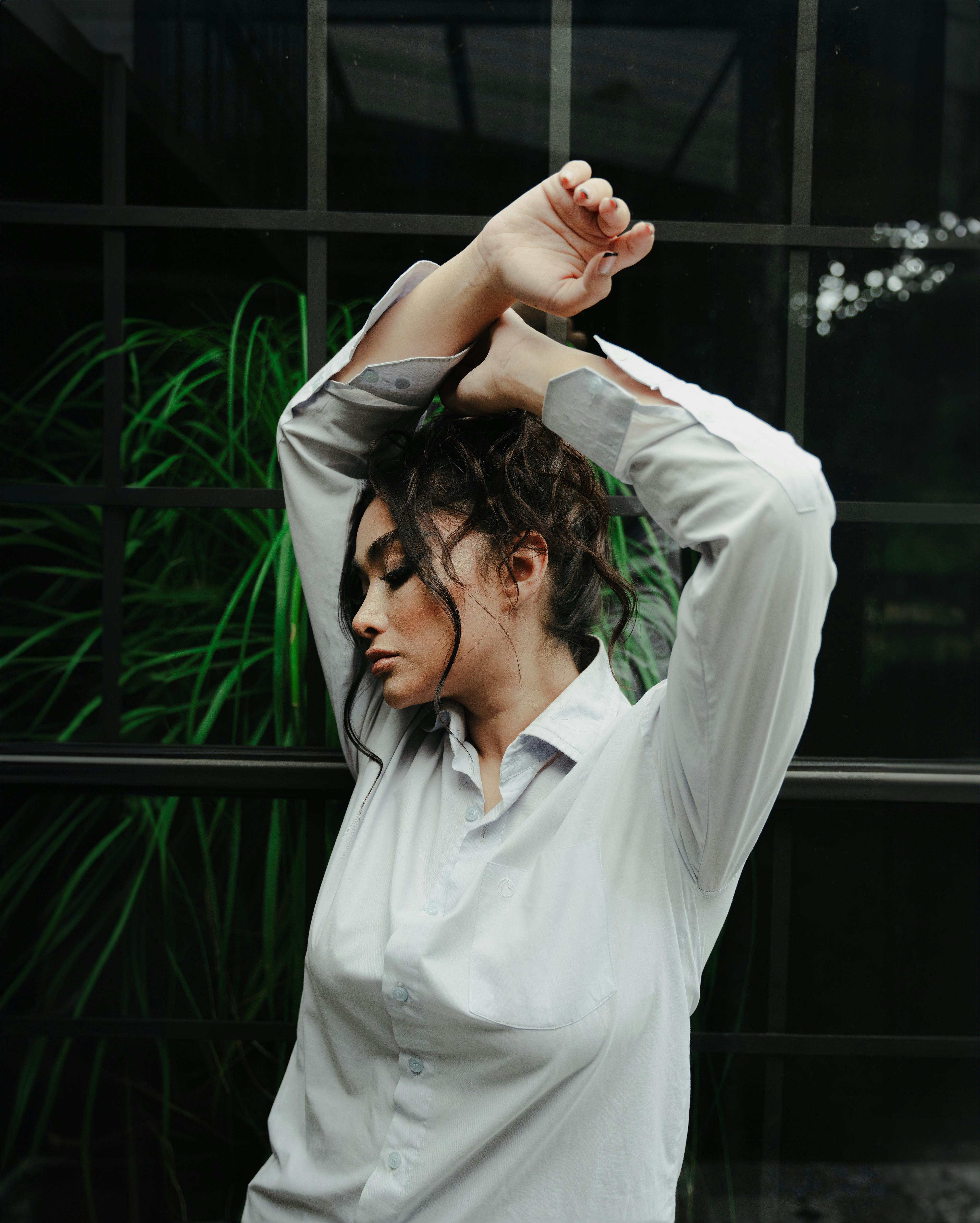 Brunette Woman Standing with Arms Raised · Free Stock Photo