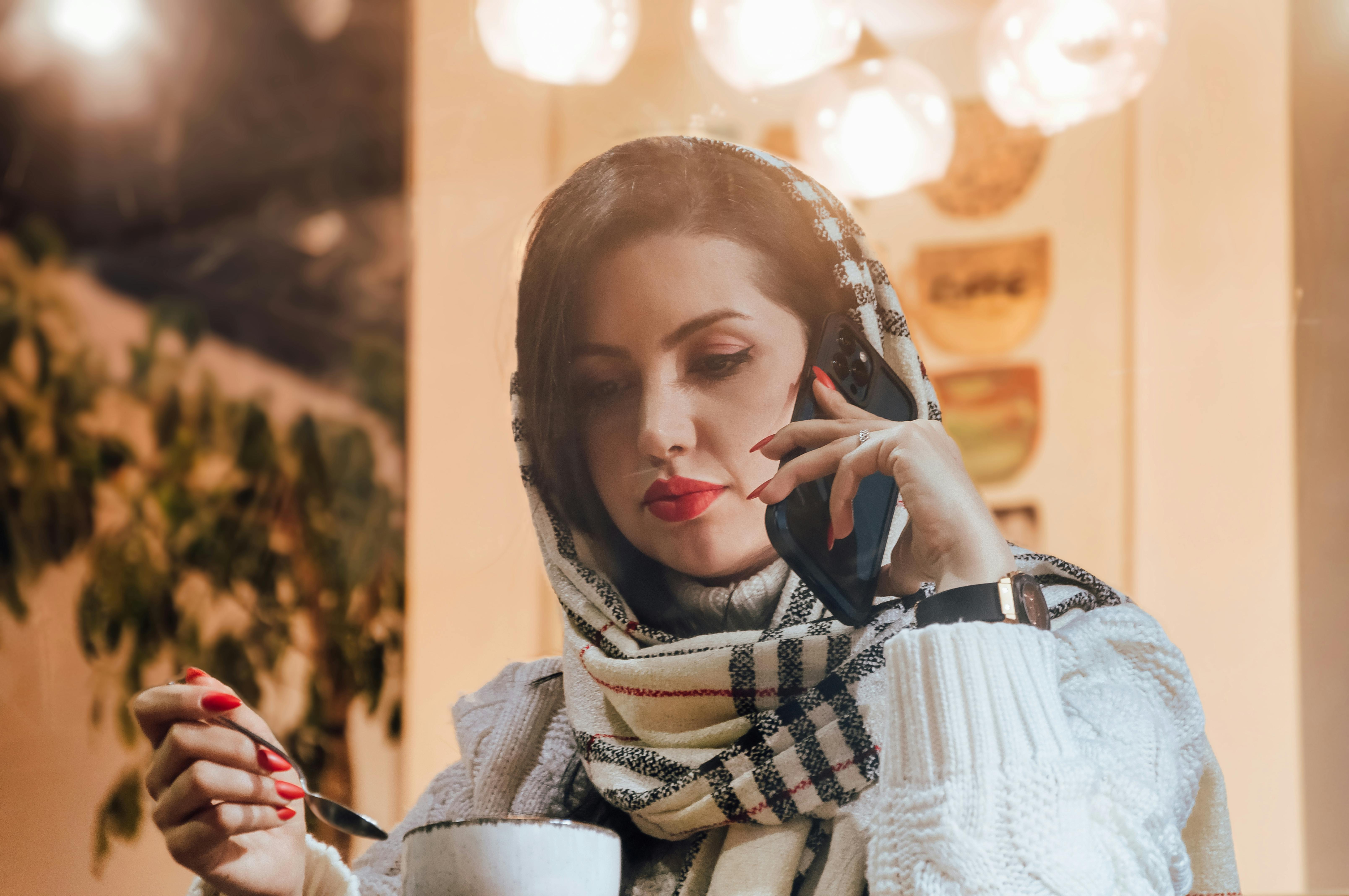 A woman in a scarf is talking on her phone · Free Stock Photo