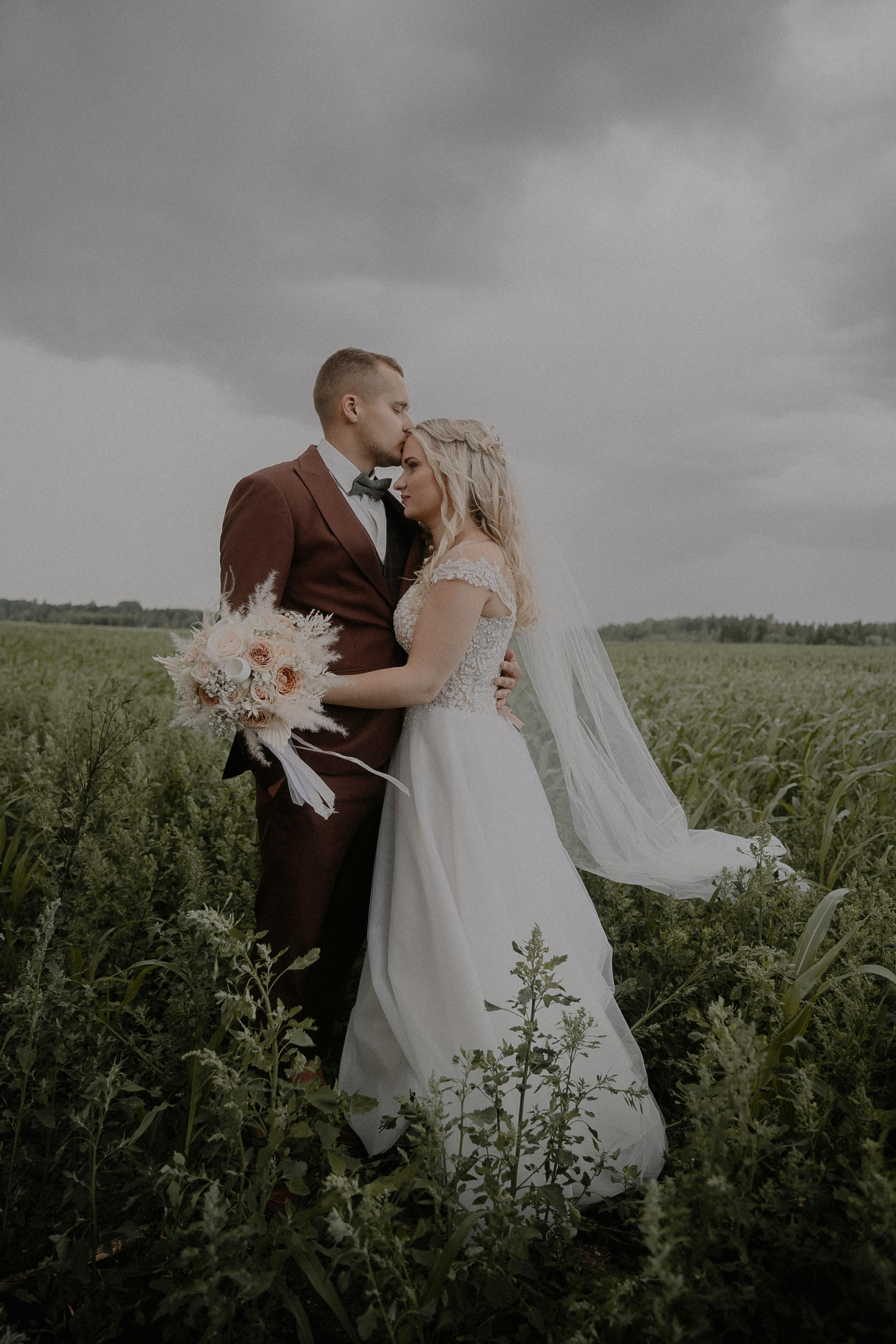 Groom Kissing the Bride on the Forehead · Free Stock Photo