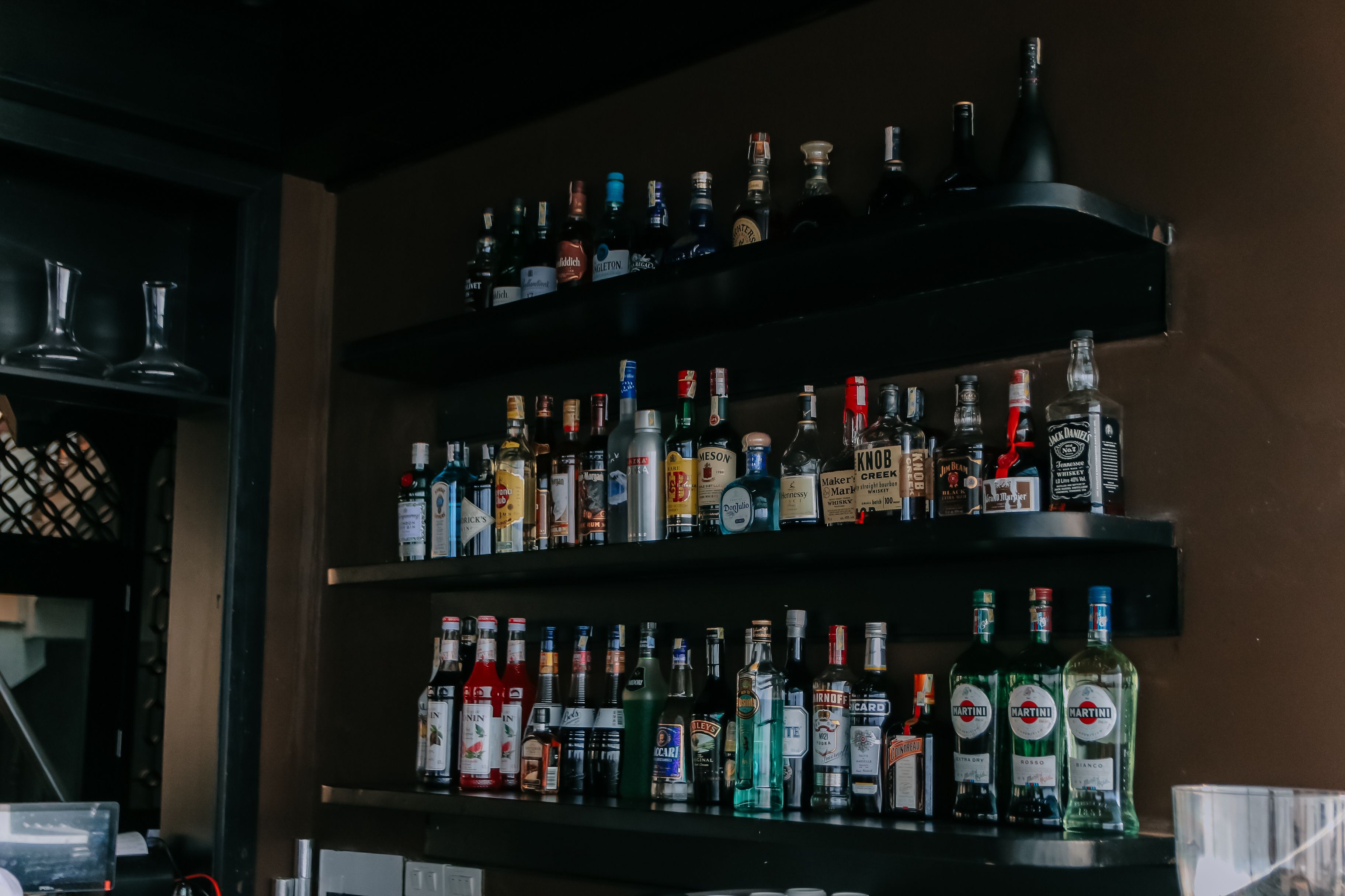Bottles of Various Alcoholic Beverages Displayed on Shelves in a Bar ...