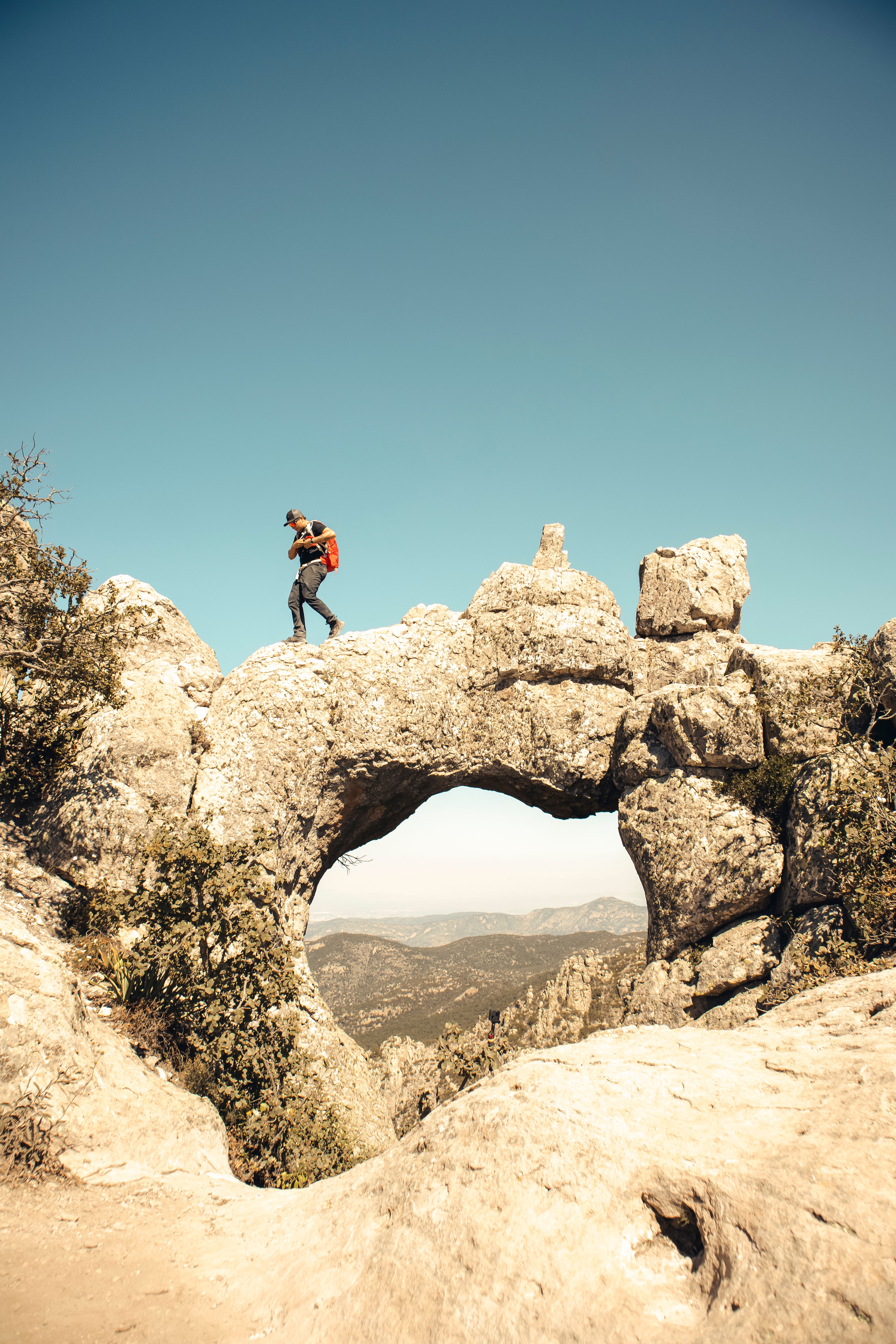 Landscape with a Man Walking on a Natural Arch · Free Stock Photo