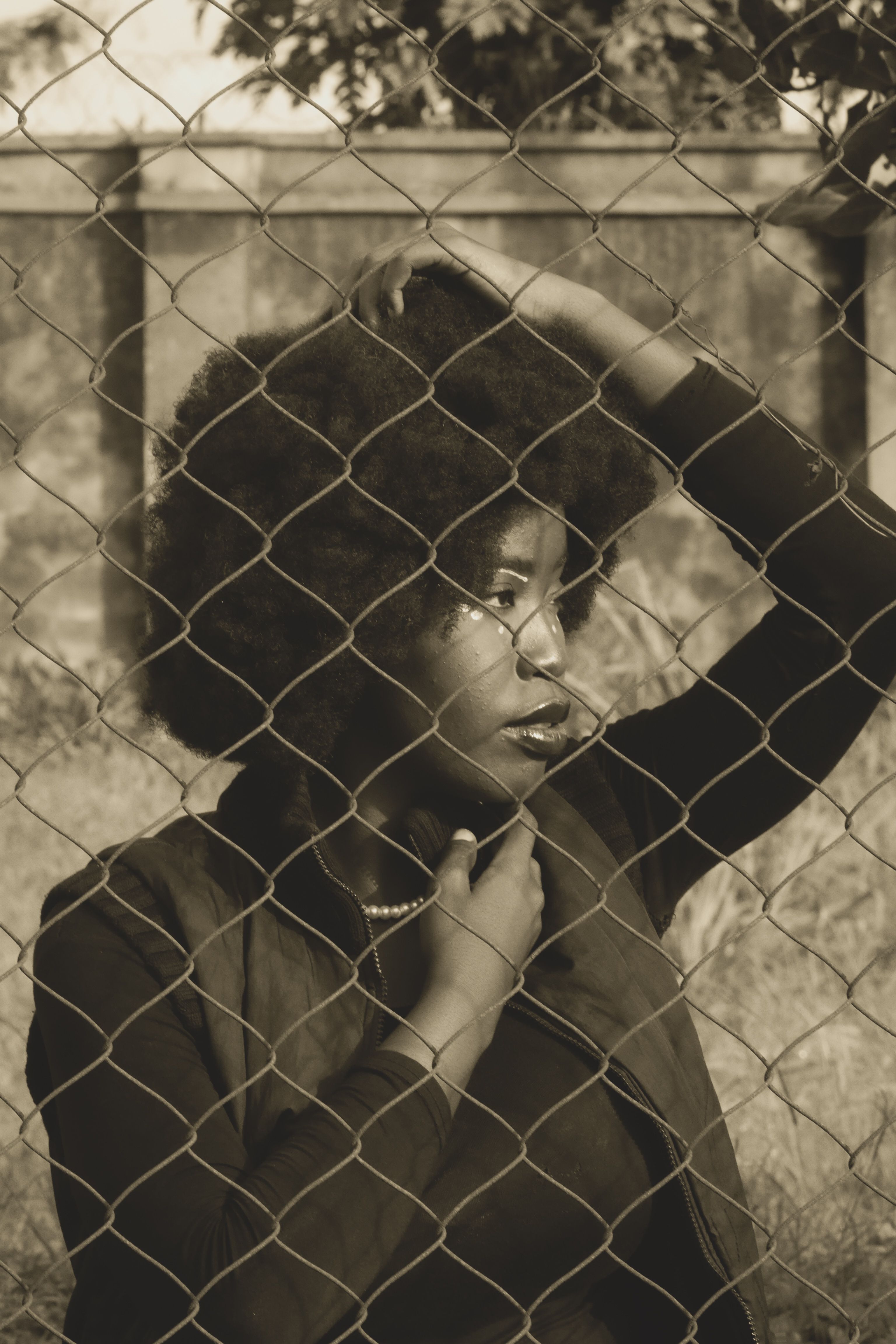 Young Woman Standing behind a Chain Fence · Free Stock Photo