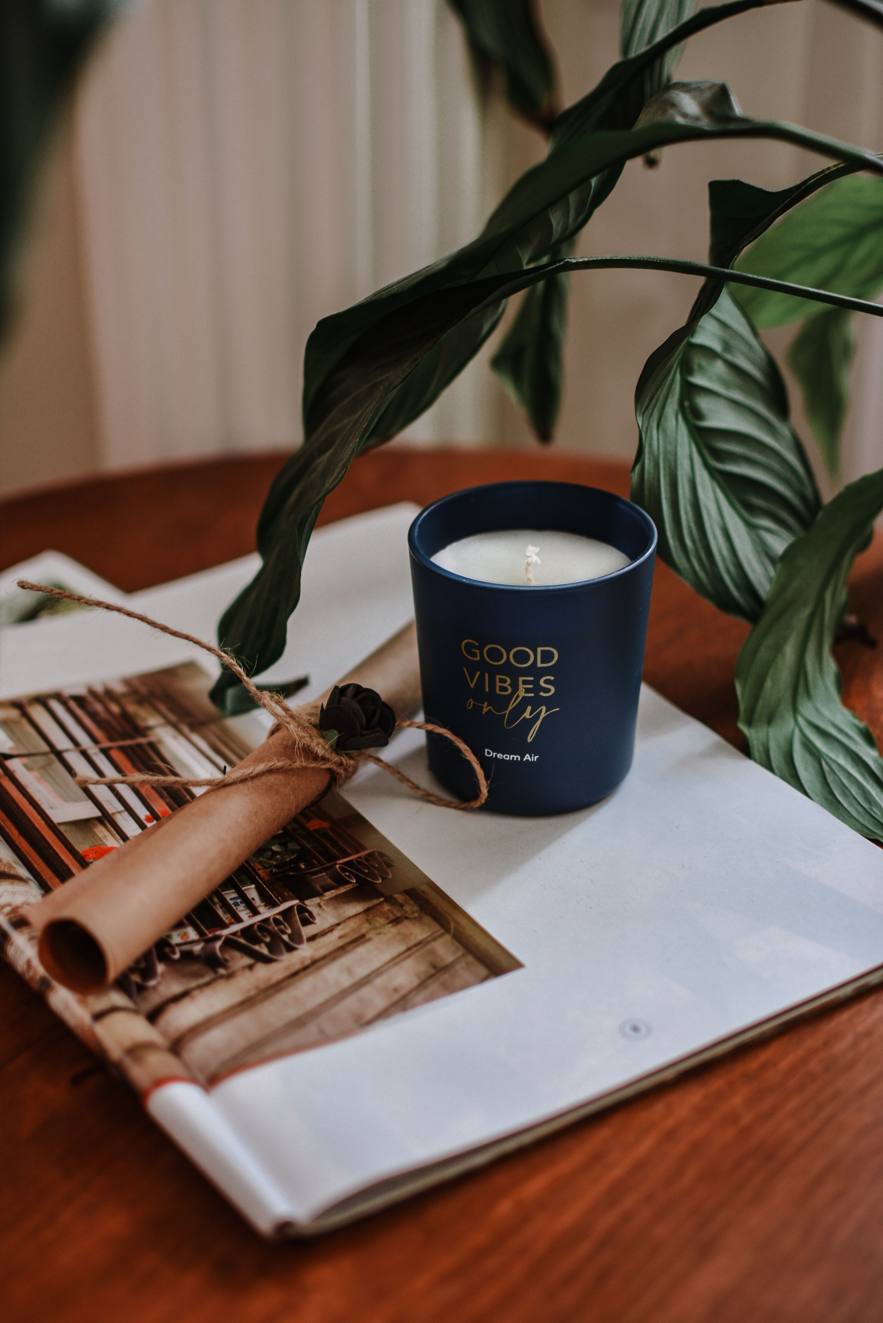 Good Vibes Scented Candle and a Roll of Parchment Tied with String ...