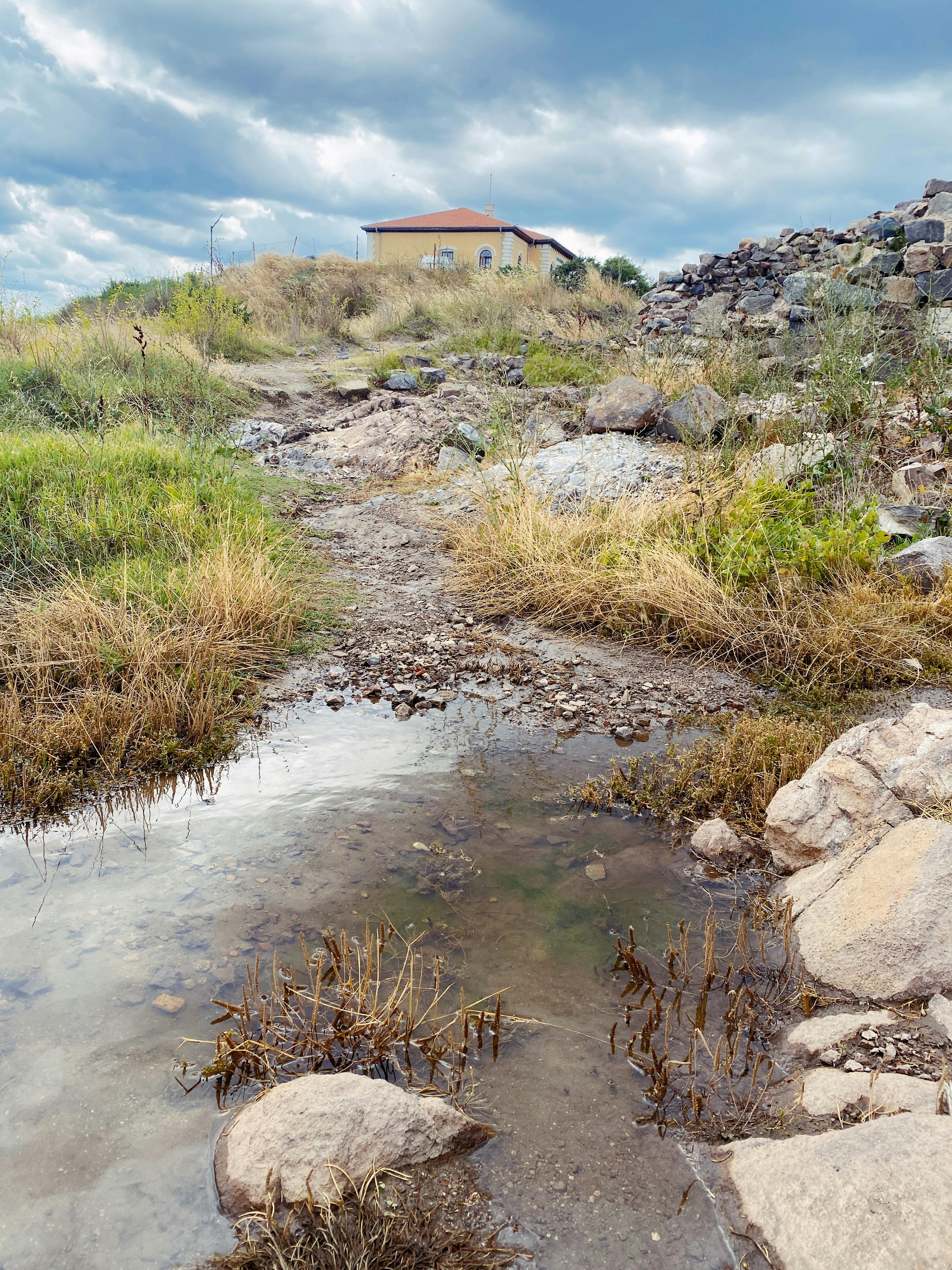 Puddle under Hill in Village · Free Stock Photo