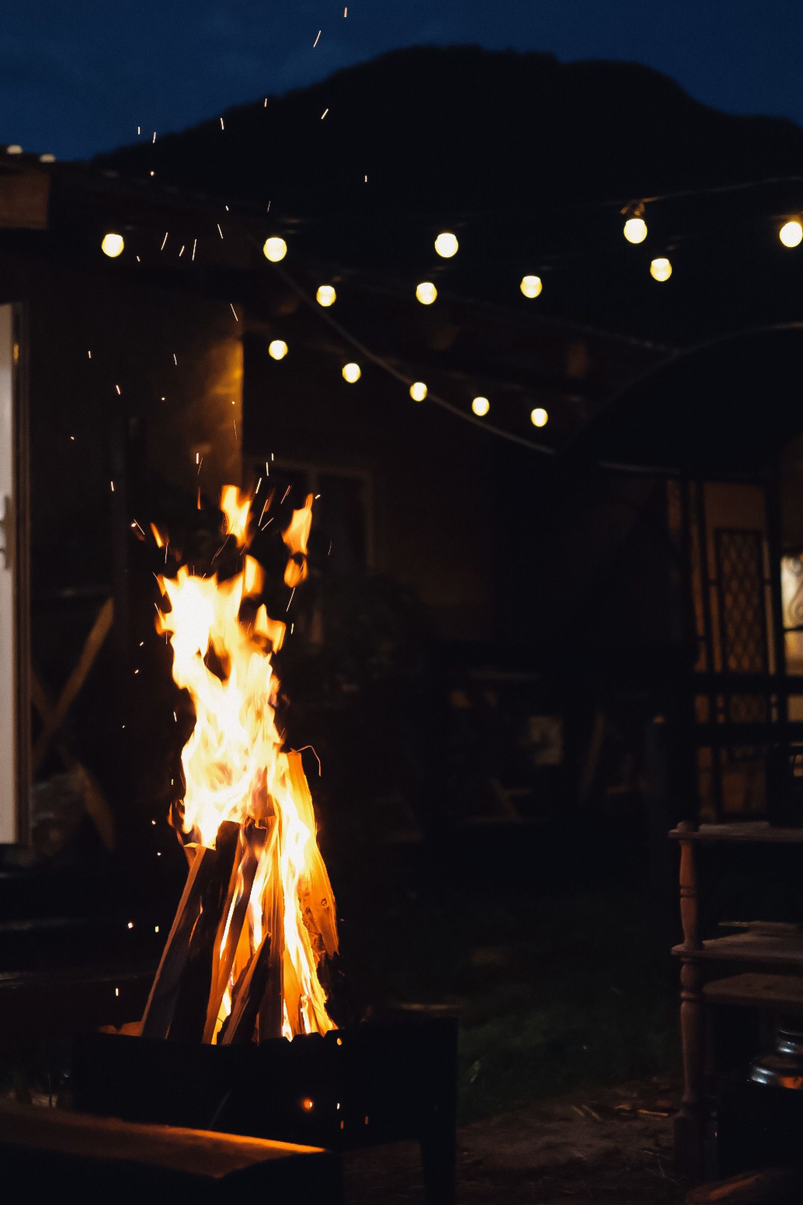 View of a Fire in a Fireplace Outside and String Lights at Night · Free ...