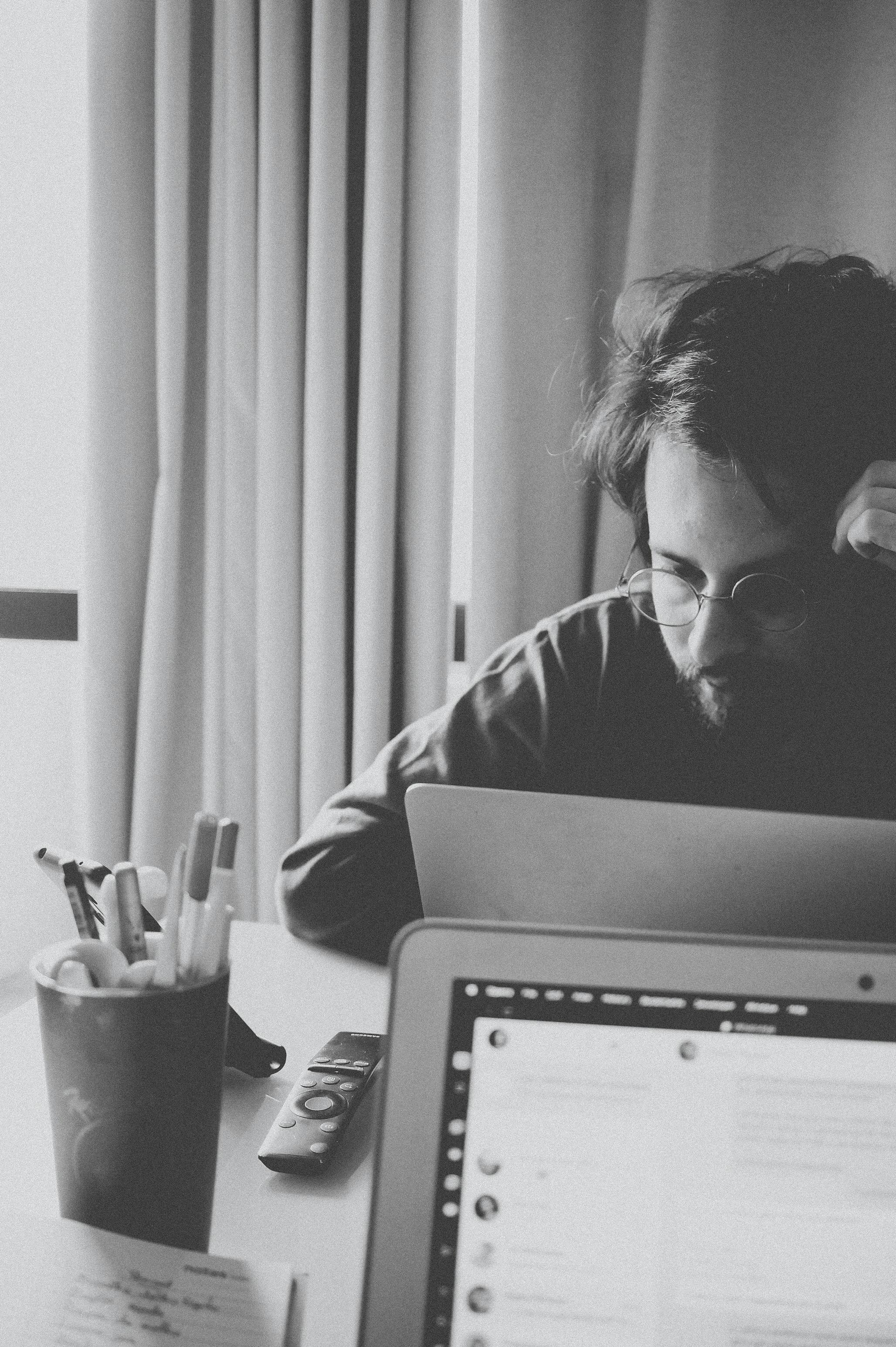 Man Sitting Behind Desk, Using Laptop · Free Stock Photo