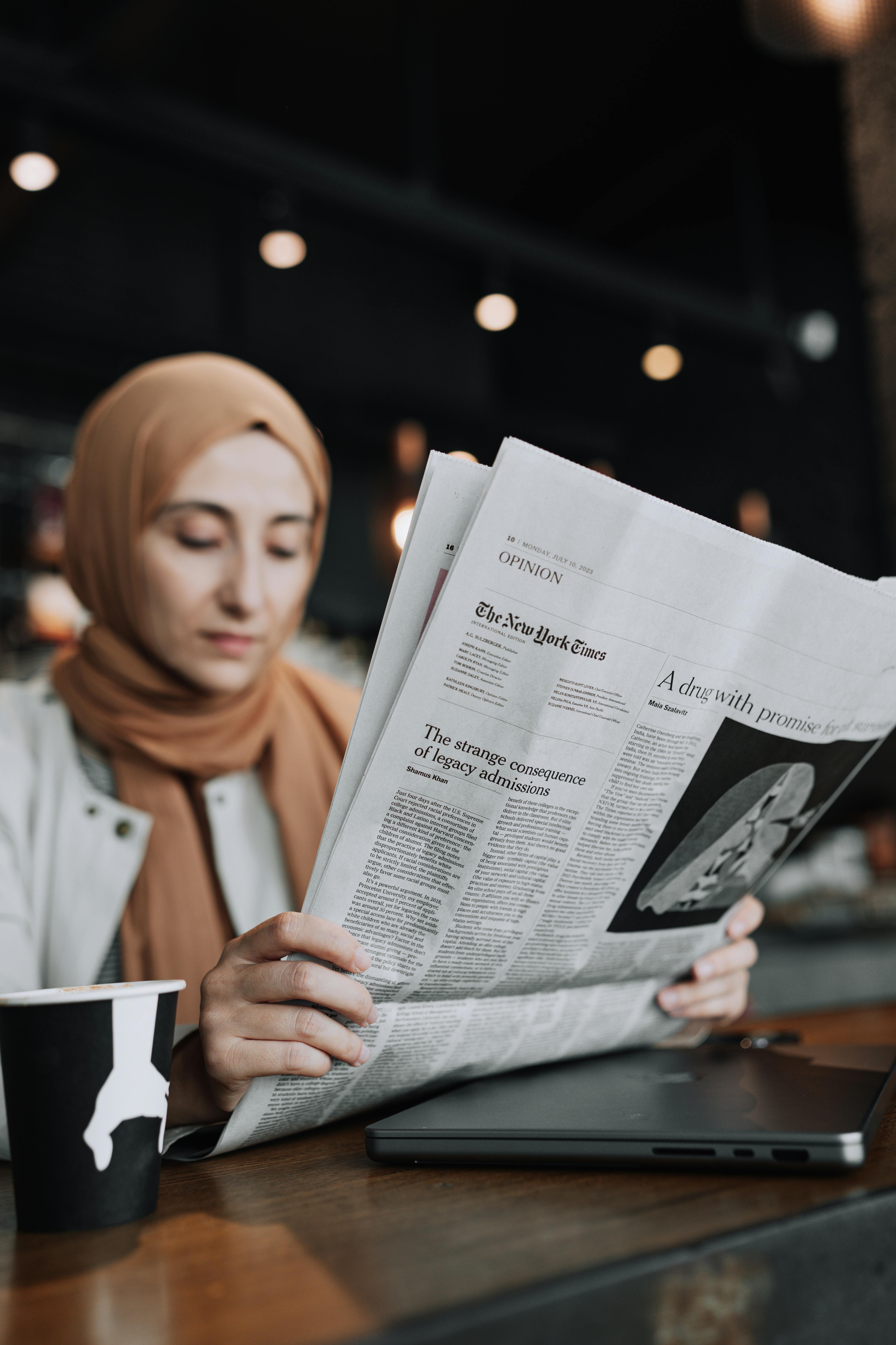 Woman in Headscarf Reading Newspaper · Free Stock Photo
