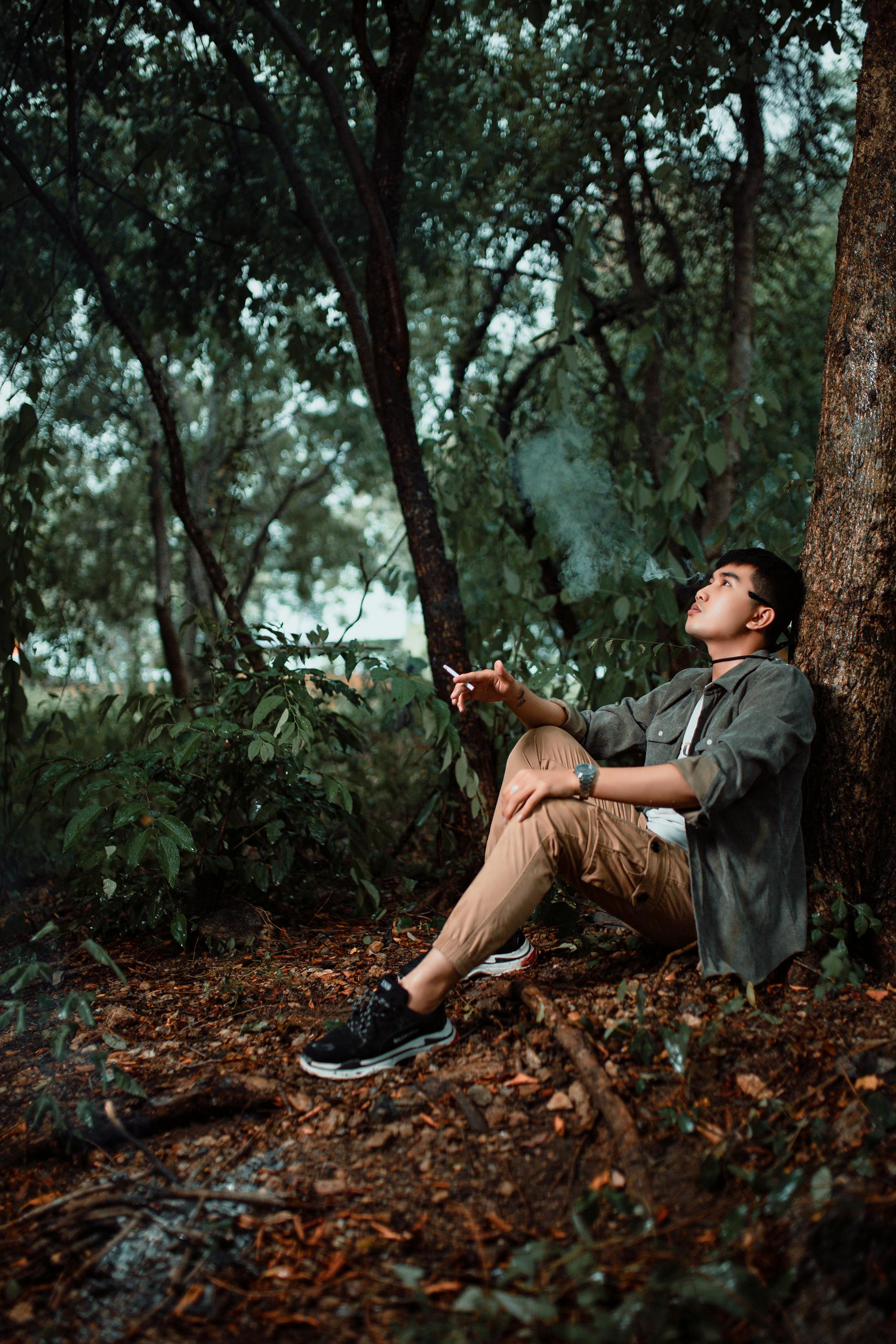 A man sitting in the woods with a cigarette · Free Stock Photo
