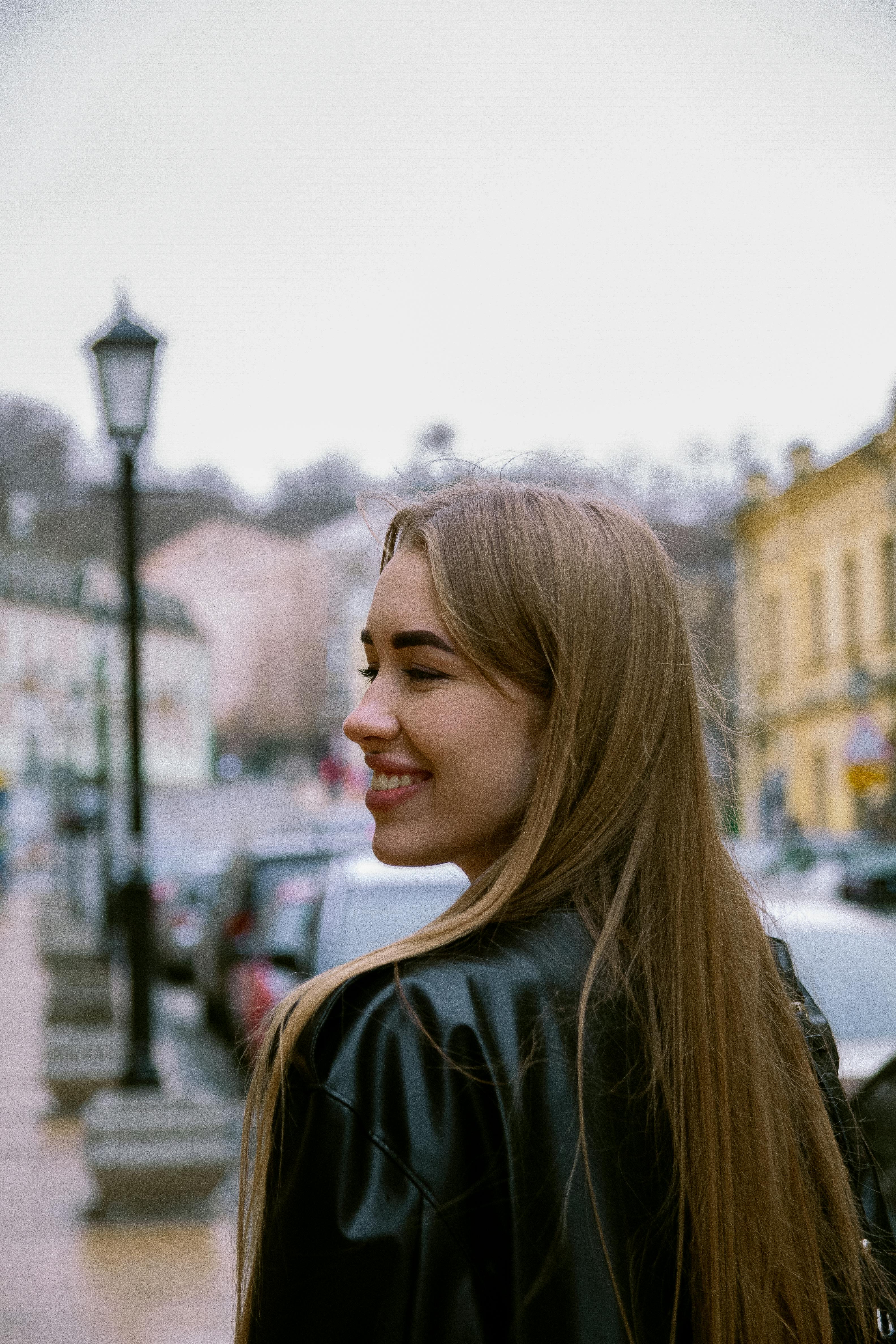 Young Woman Walking on a Sidewalk, Looking over Her Shoulder and ...