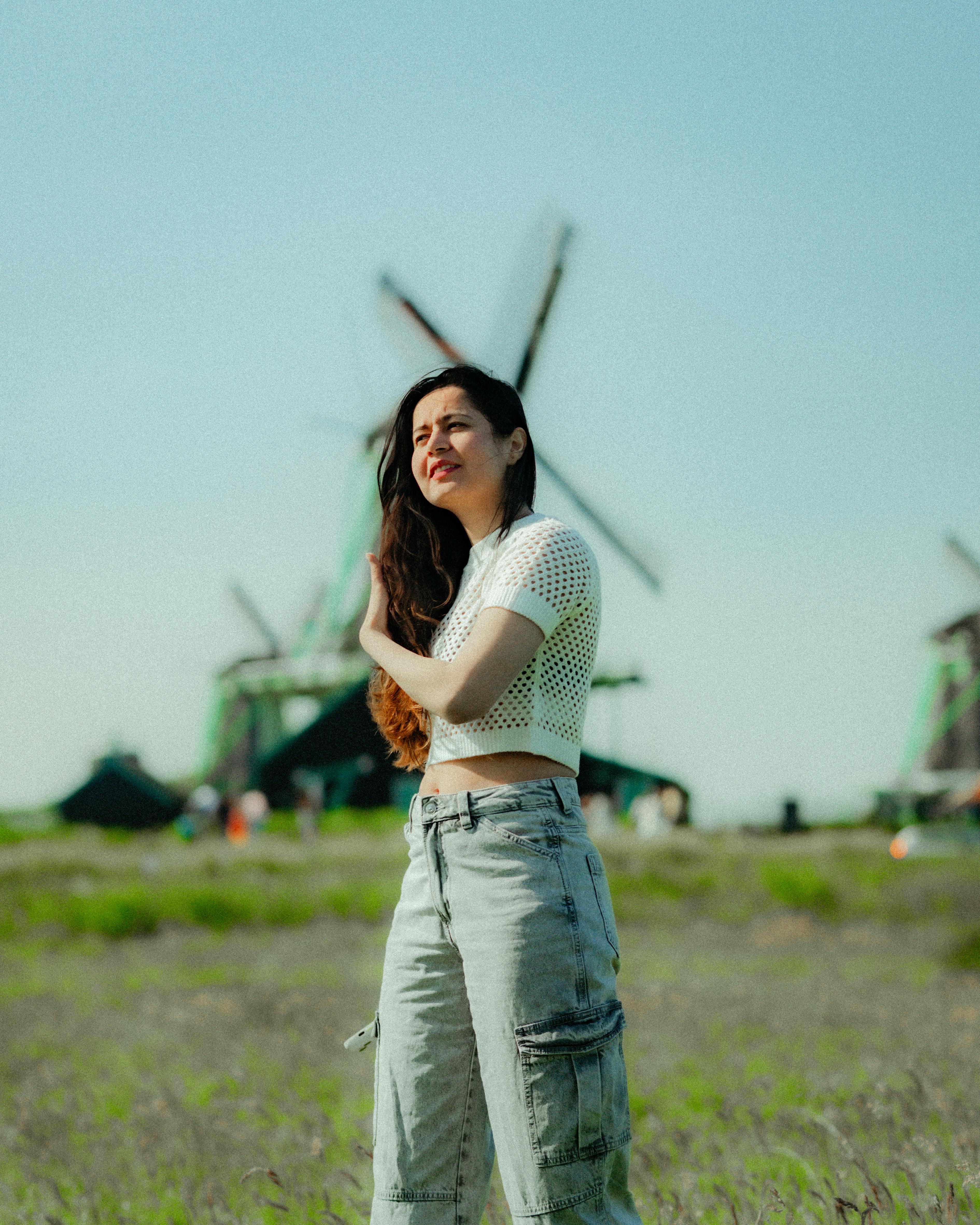 A woman standing in front of a windmill · Free Stock Photo
