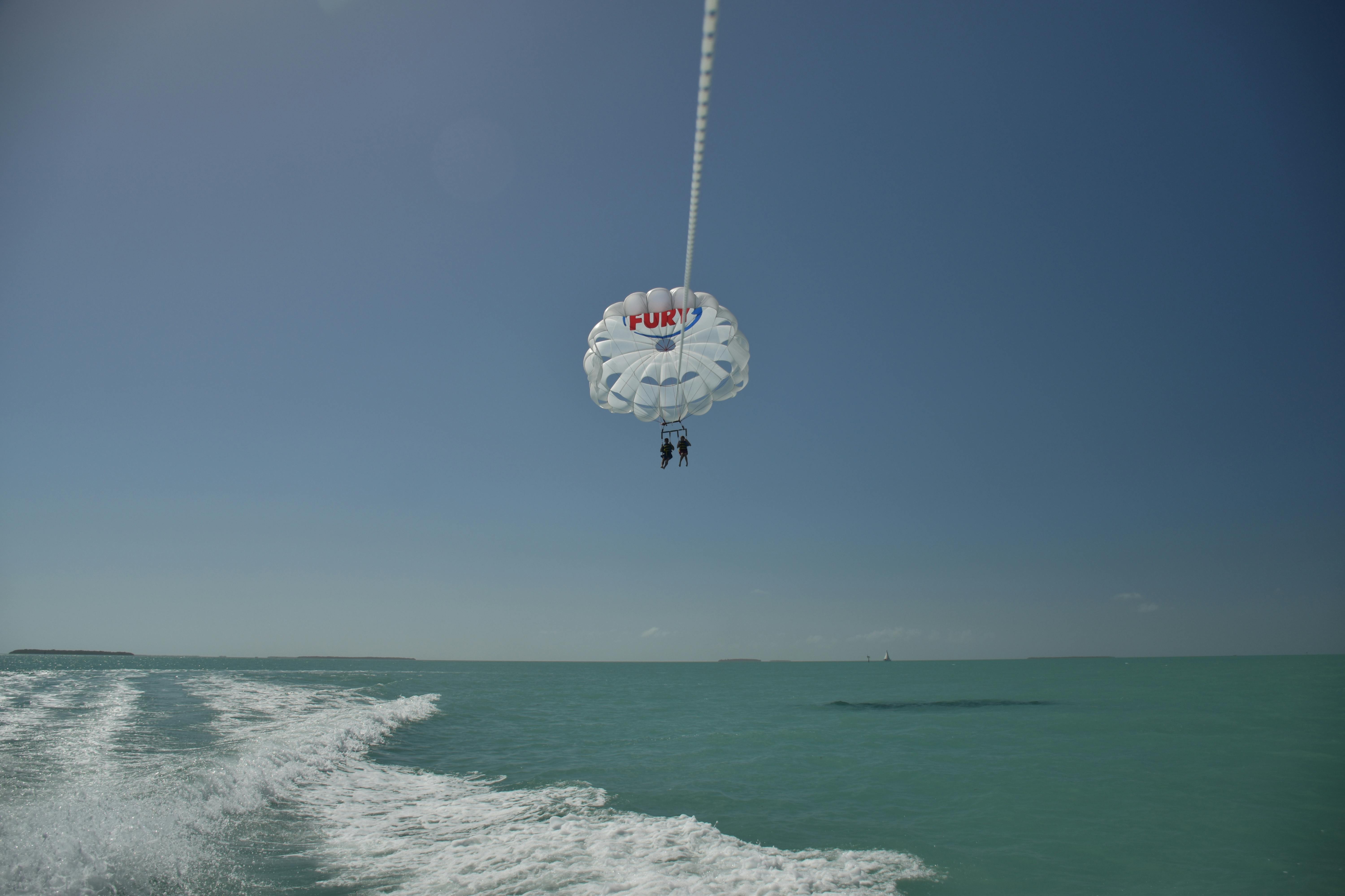 People with Parachute Flying over Ocean · Free Stock Photo