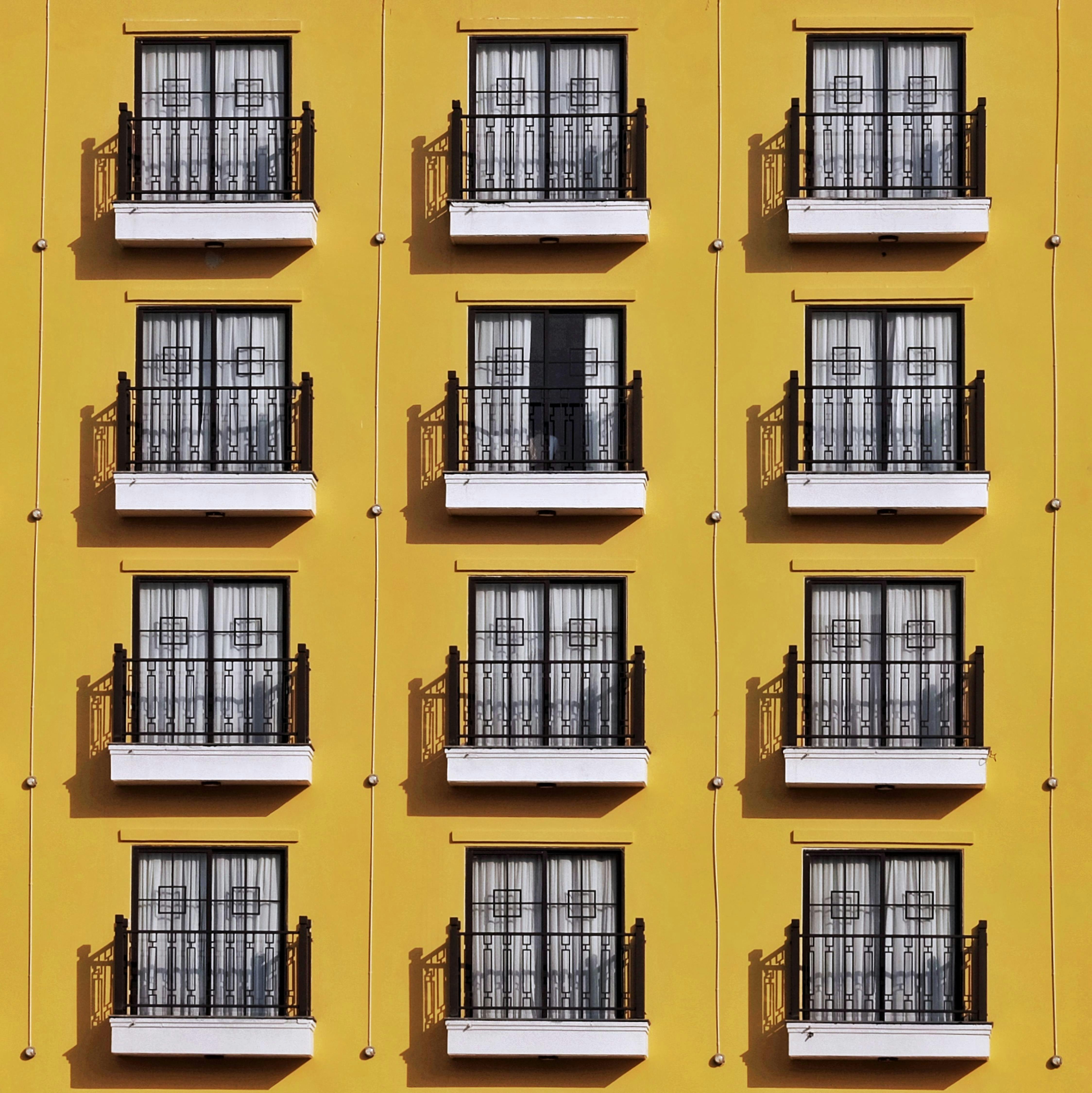 Facade of a Yellow Apartment Building with Balconies · Free Stock Photo