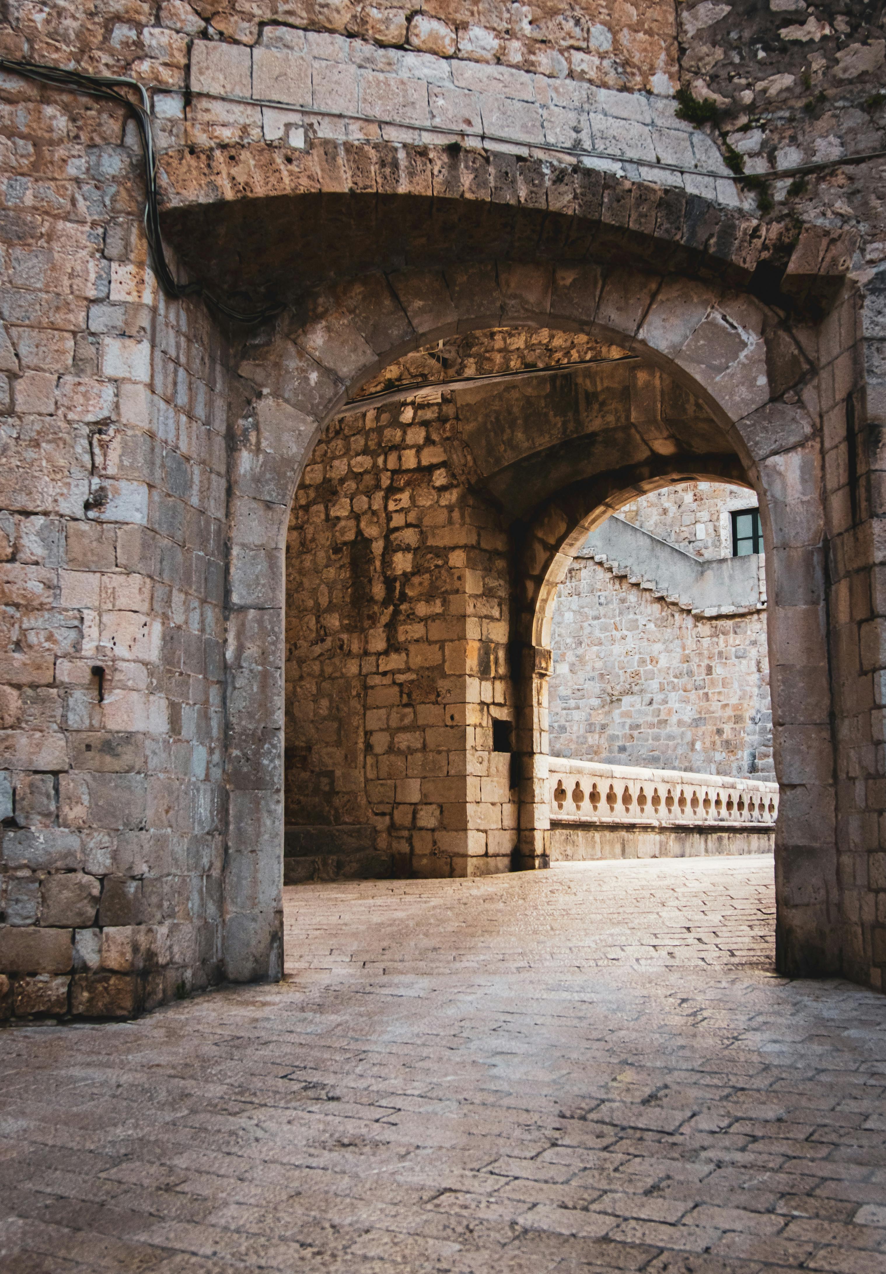 The entrance to an old stone building with a stone arch · Free Stock Photo