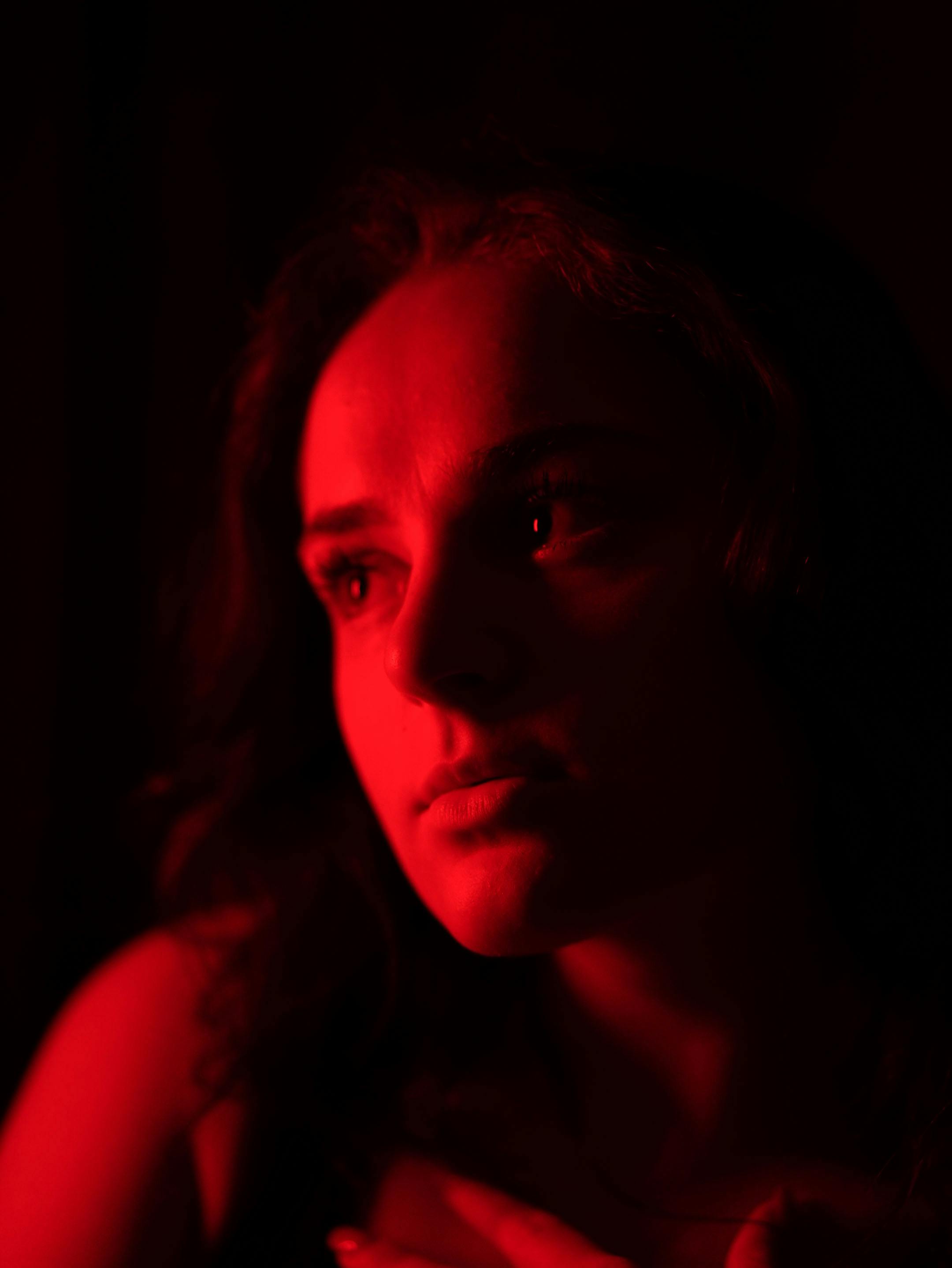 Young Woman in Dark in Red Light · Free Stock Photo