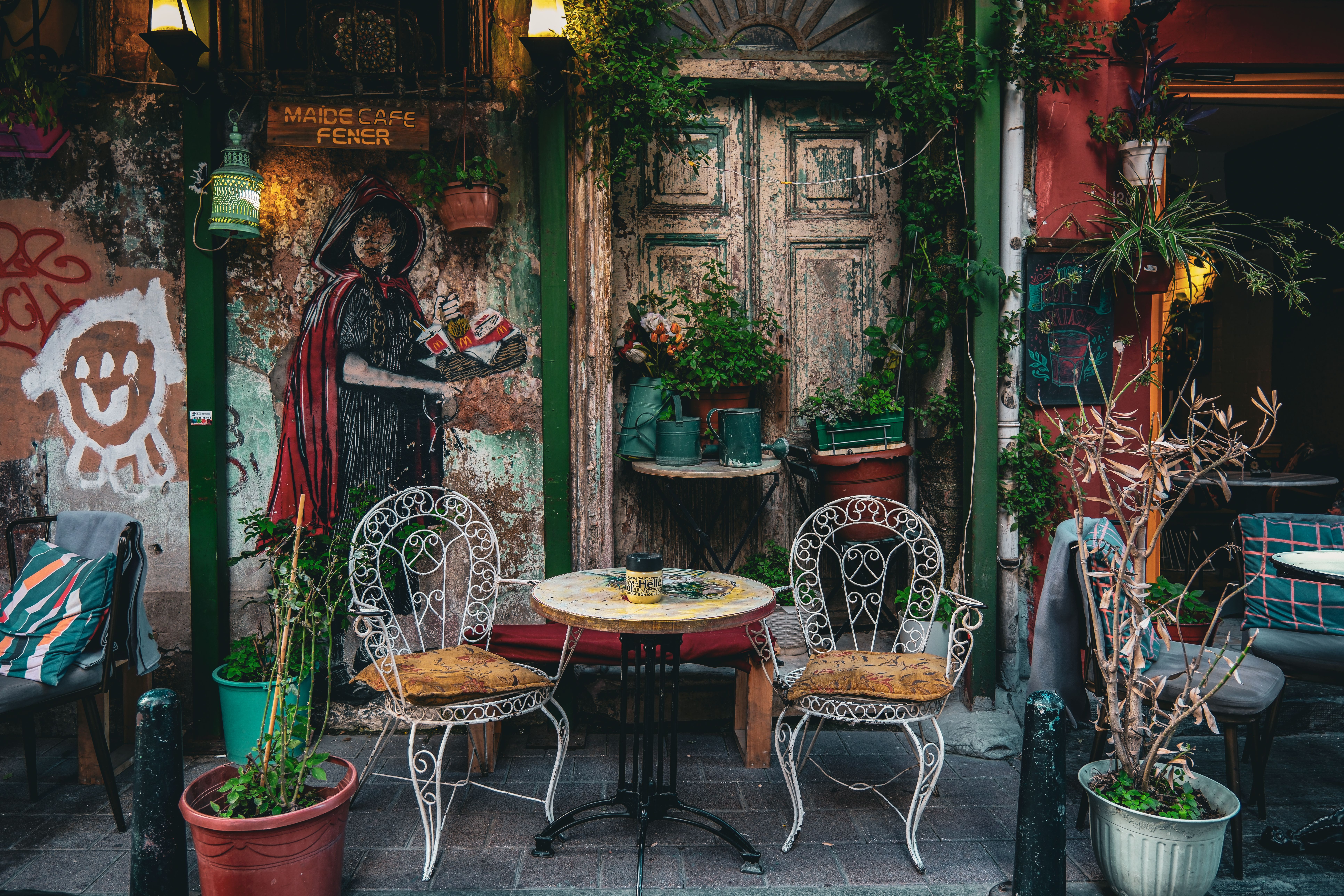 Patio of Cafe with Mural and Potted Plants · Free Stock Photo