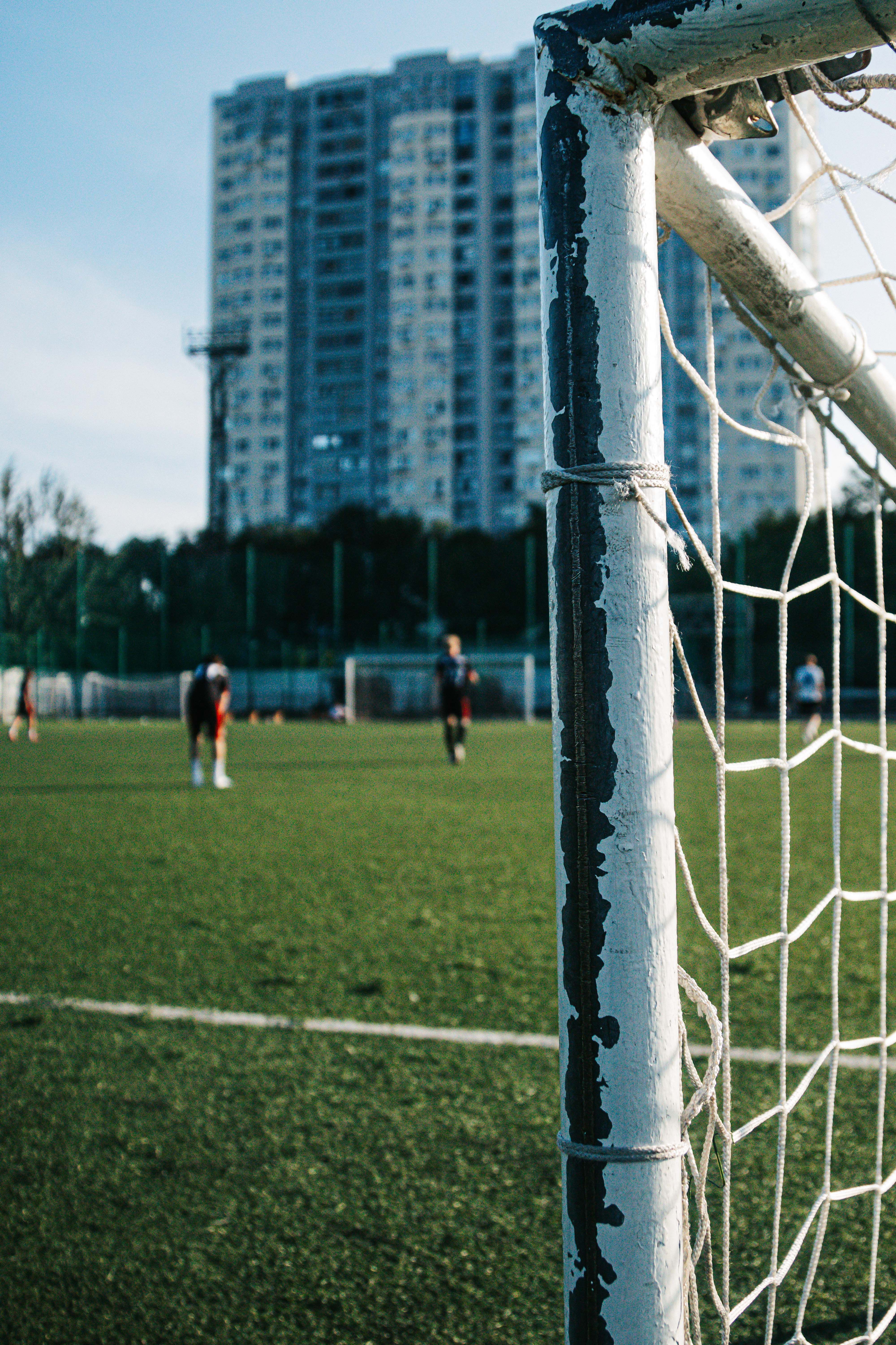 Urban Soccer Field with Goal and Towering Building · Free Stock Photo