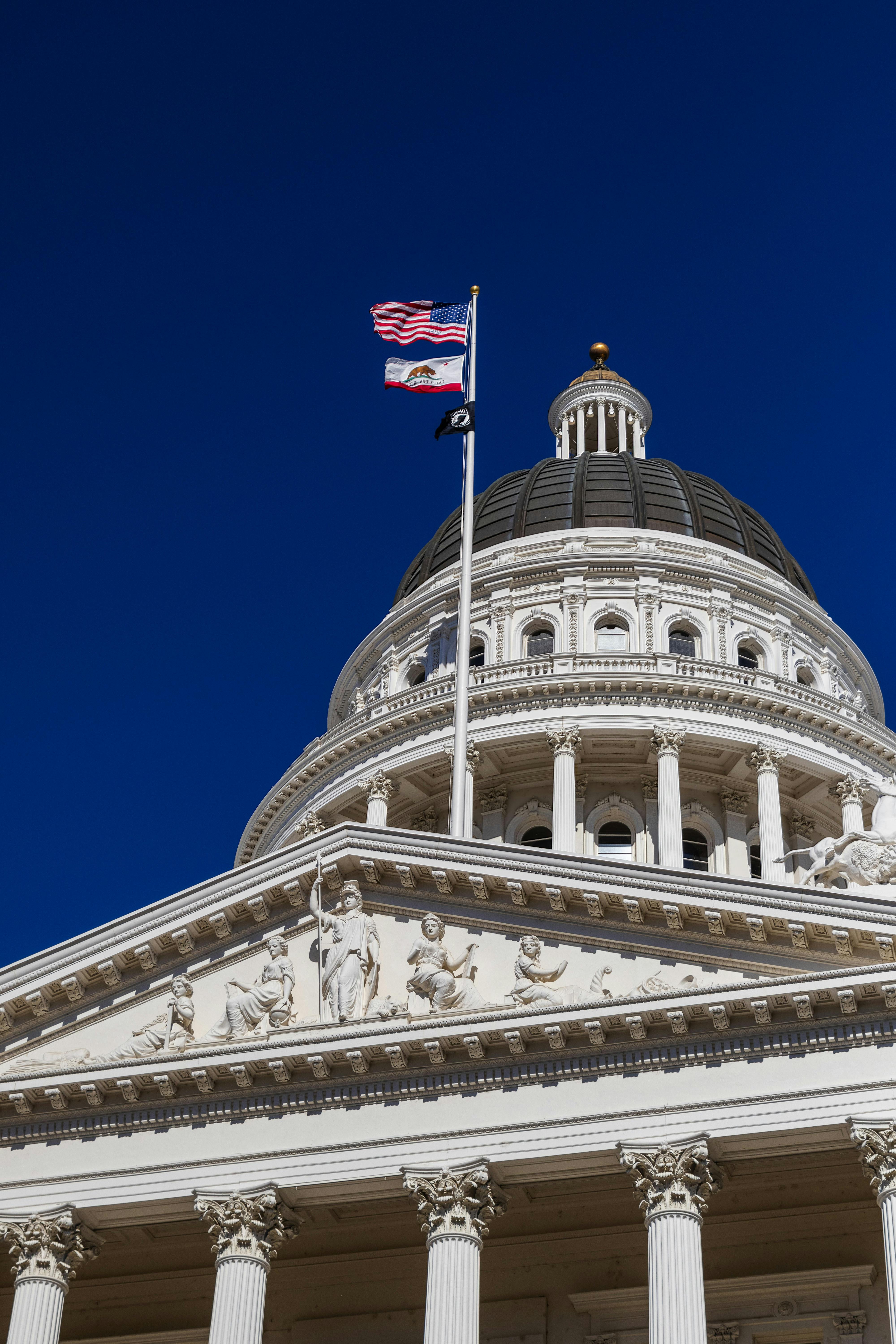 Flags Hanging on Pole near Historic Building with Dome · Free Stock Photo