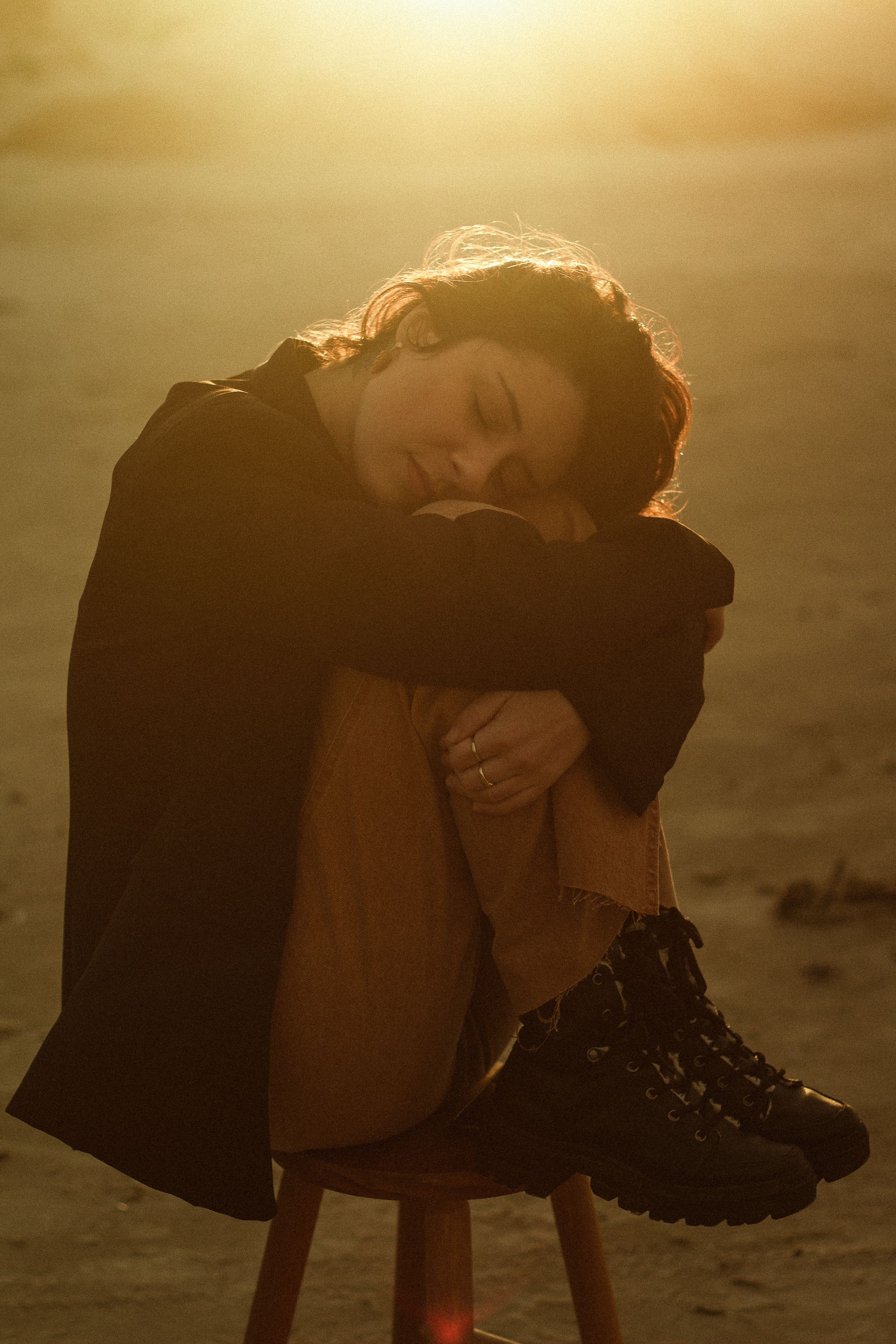 Woman Sitting with Legs Tucked under Chin · Free Stock Photo