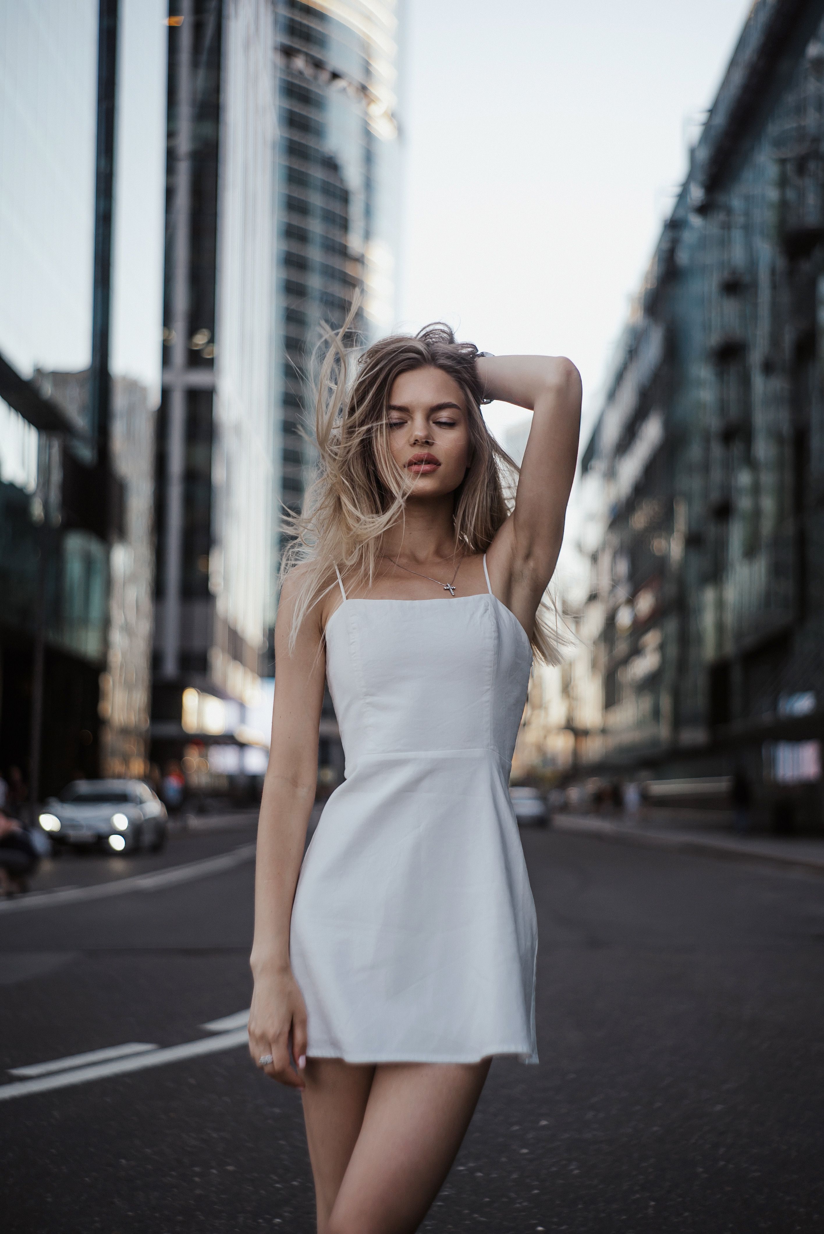 Blonde Model in Blue Dress Standing behind Bush · Free Stock Photo