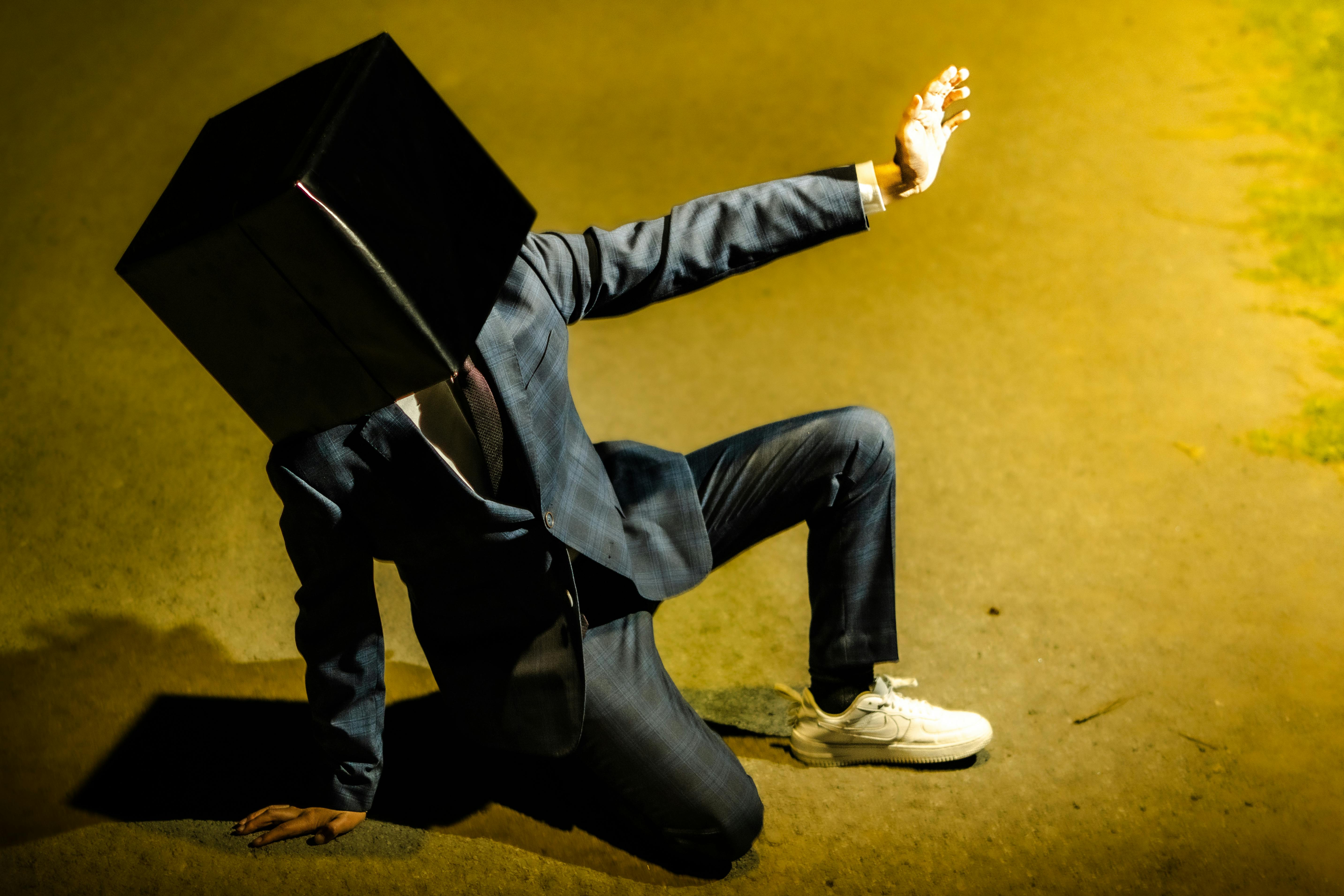 Model in Suit and with Cardboard Box on Head · Free Stock Photo