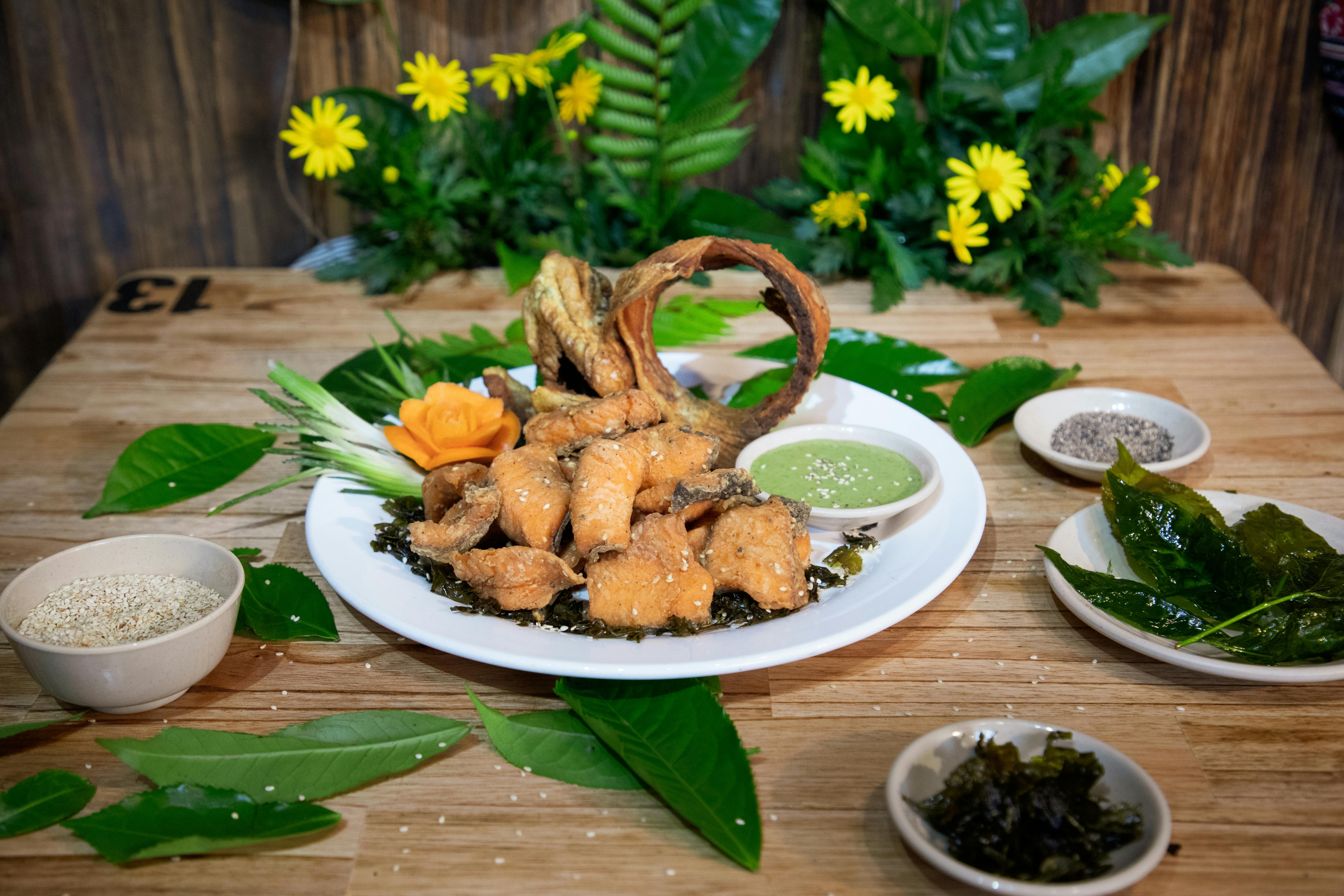 Plate pf Sturgeon Slices on a Table Decorated with Yellow Flowers and ...