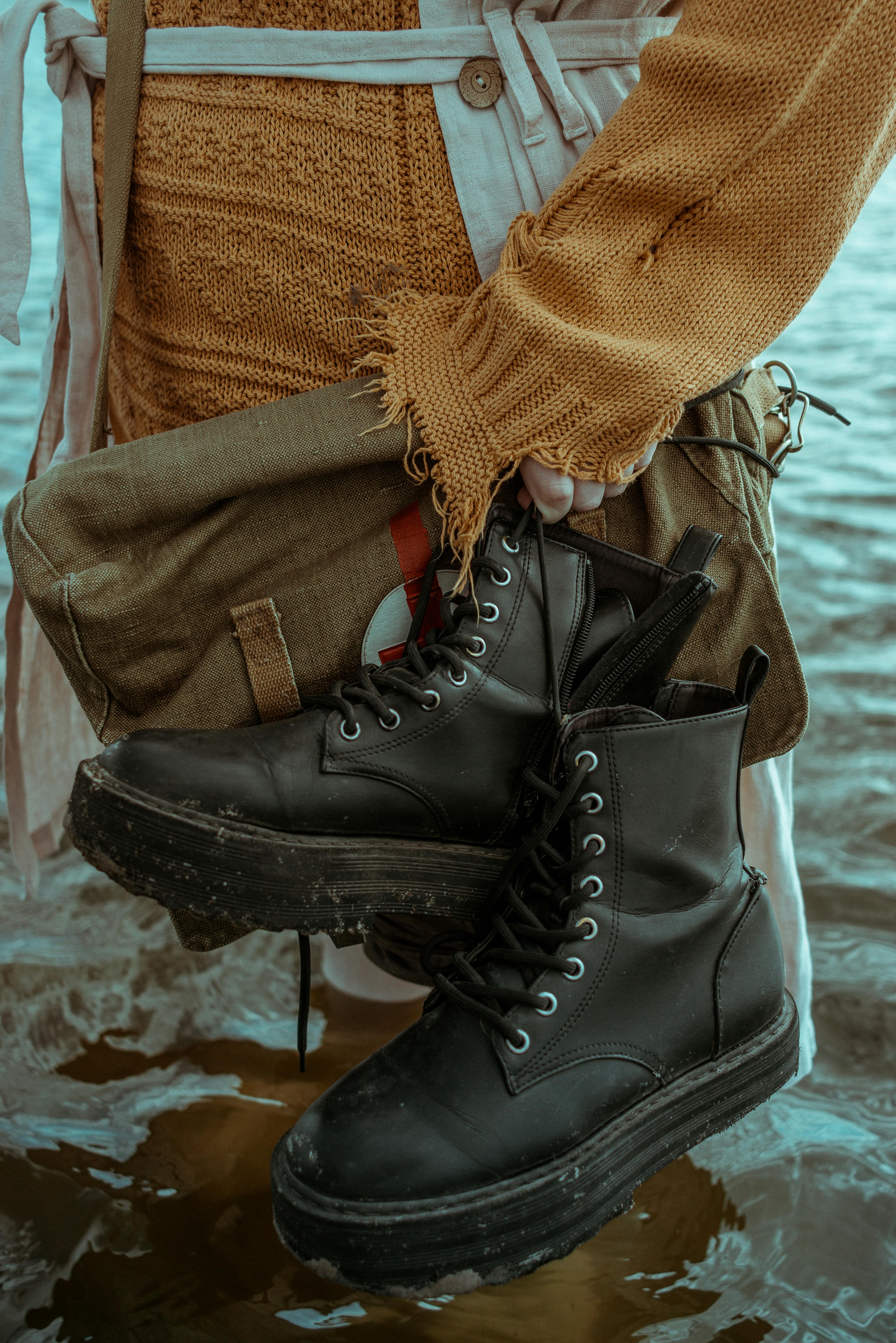 Woman Standing in the Sea and Holding Boots in her Hand · Free Stock Photo
