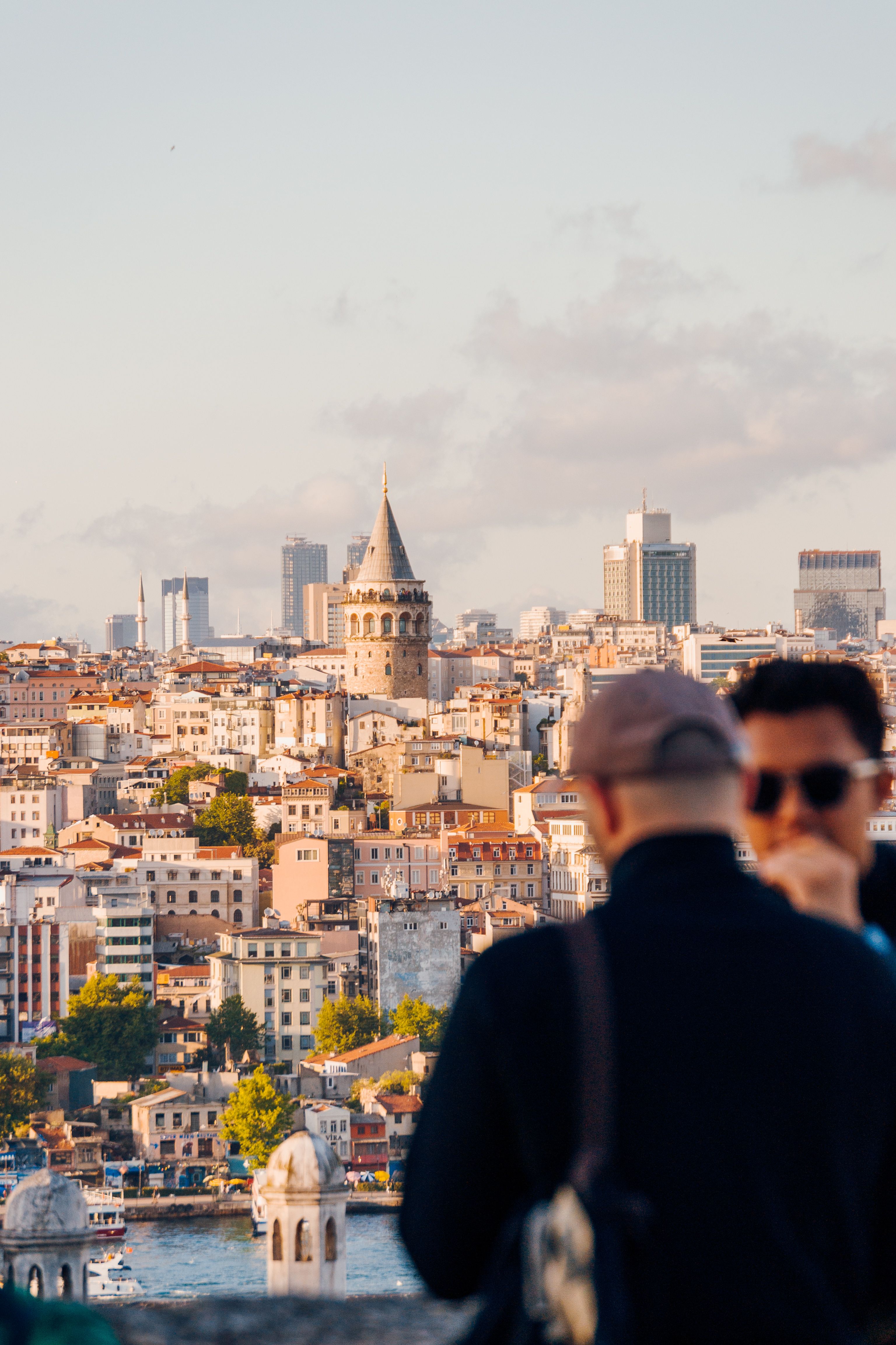 Men in Istanbul with Galata Tower behind · Free Stock Photo