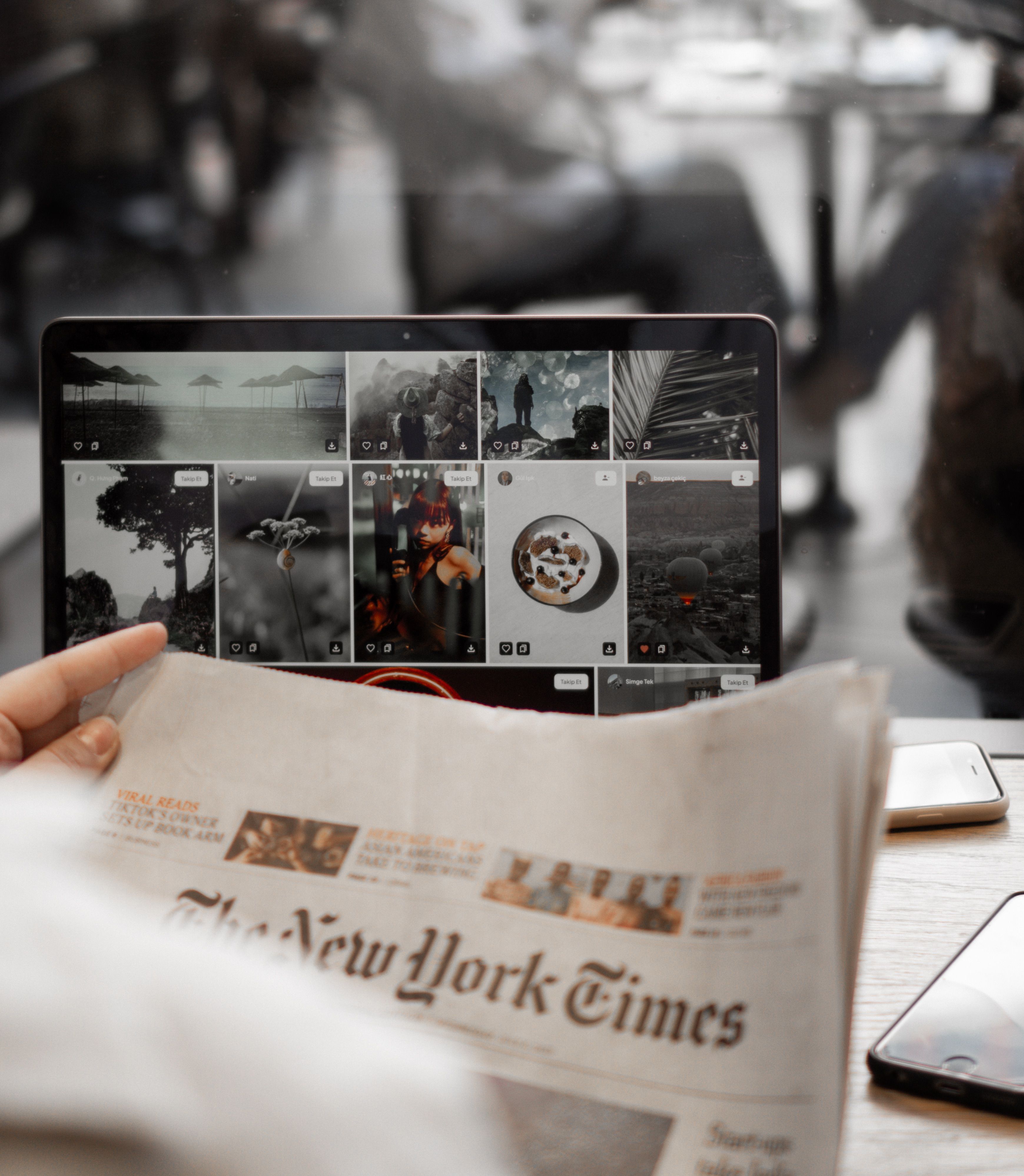 Person Reading a Newspaper and Using a Laptop · Free Stock Photo