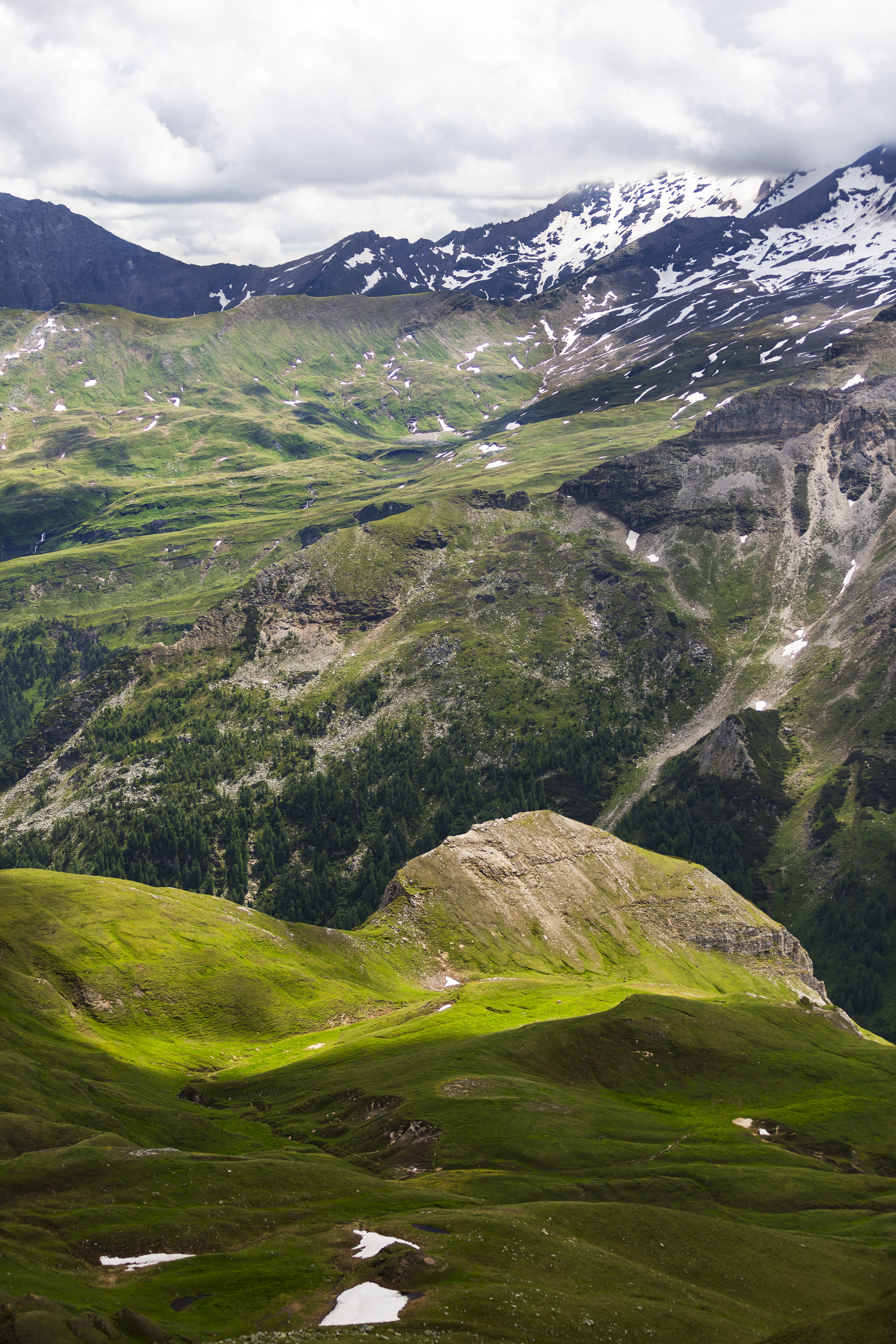 Green Slopes of a Mountain Range with Snowcapped Peaks · Free Stock Photo