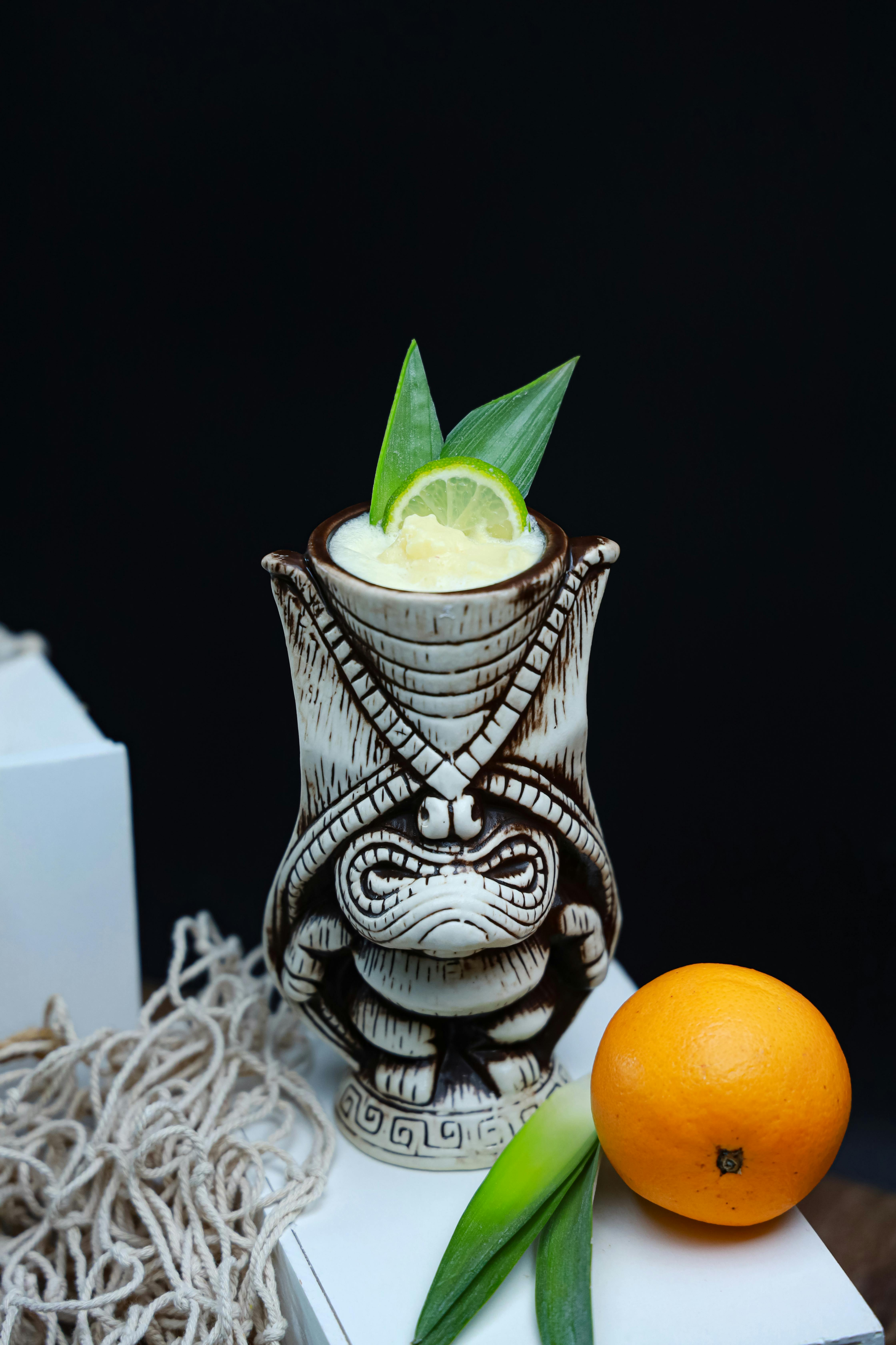 A tiki mug with a lime and orange slice · Free Stock Photo