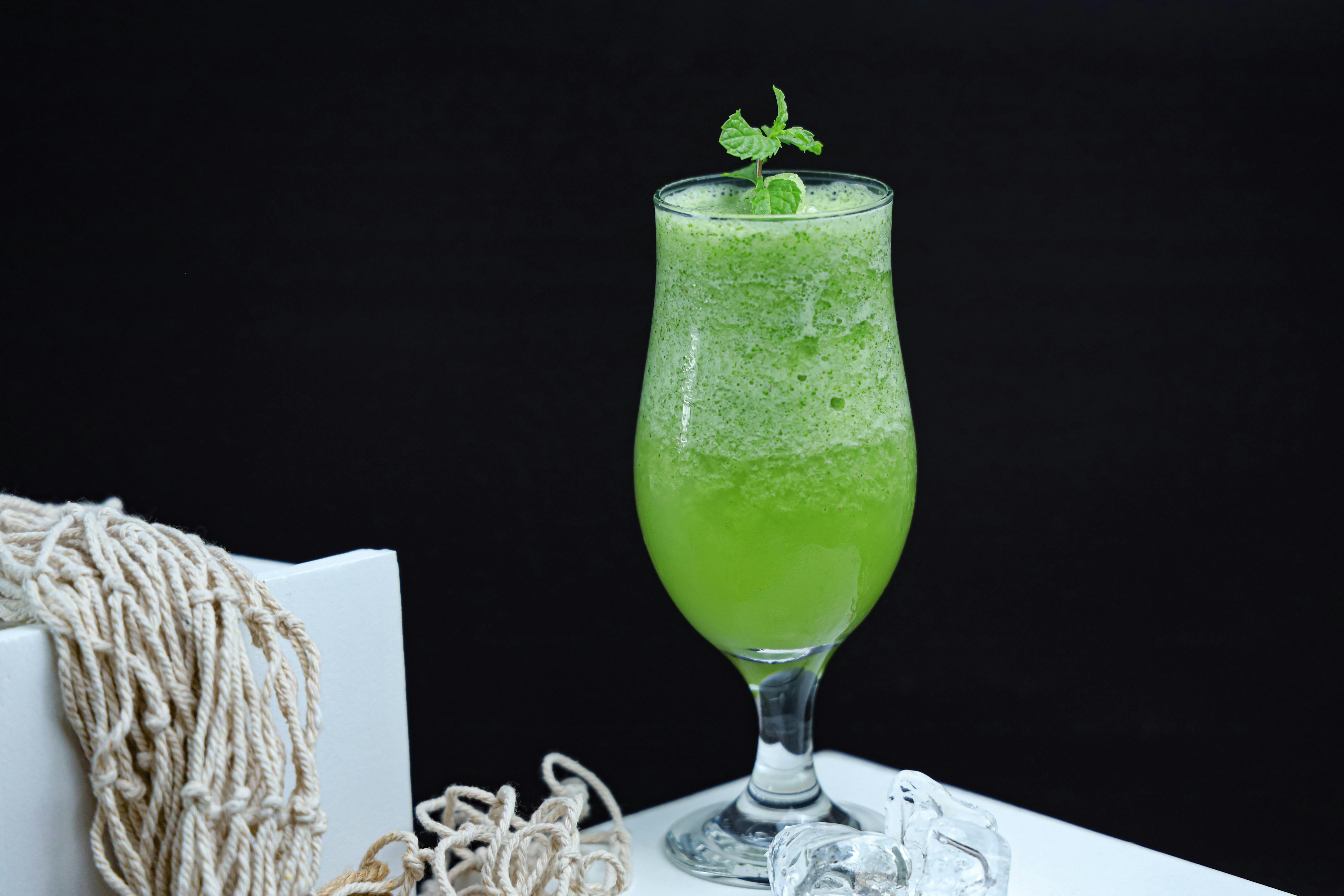 Close-Up Photograph of a Vegetable Smoothie Beside an Angel Sculpture ...