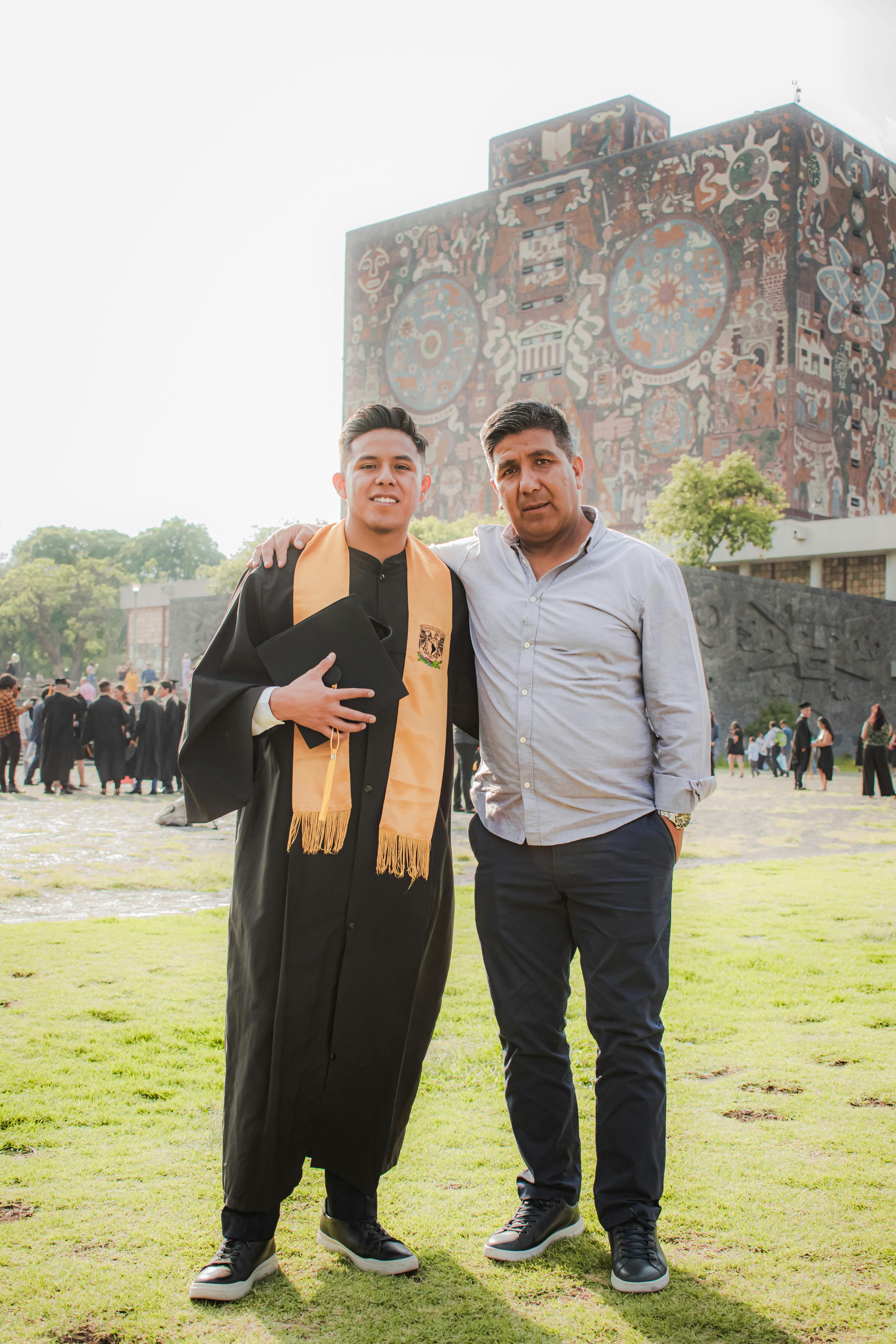 Father and Graduate Posing by UNAM Building · Free Stock Photo
