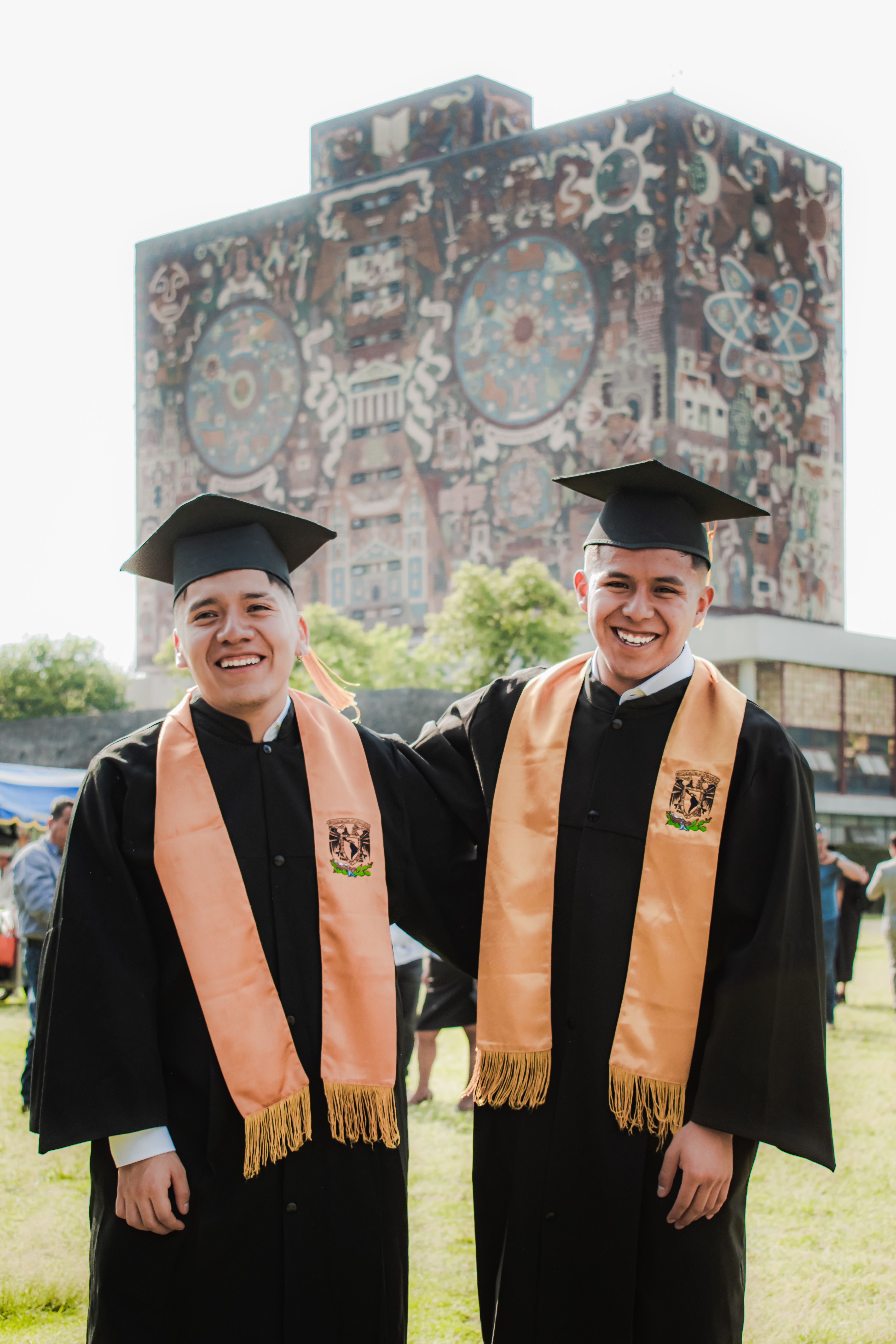 Young Men in a Graduation Gowns Standing in front of the University of ...