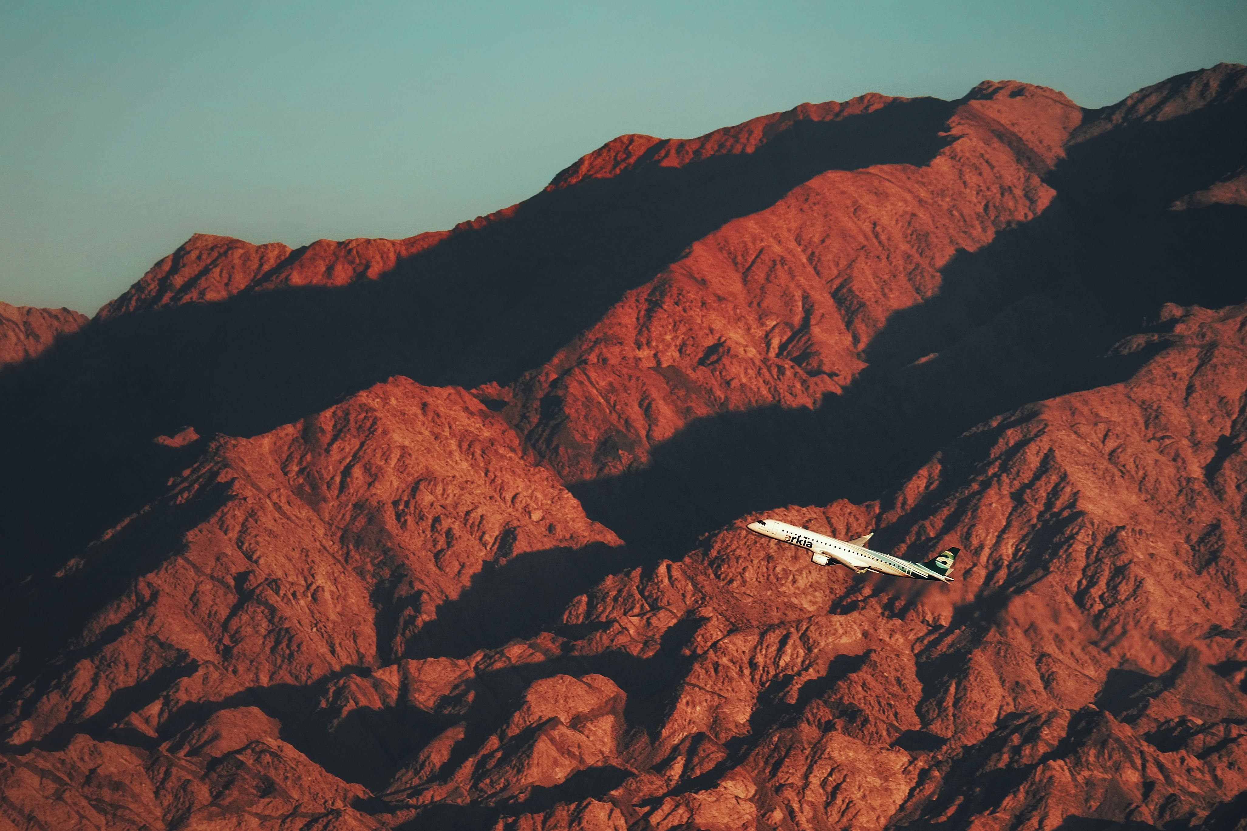 Airplane Flying Over Cliff · Free Stock Photo