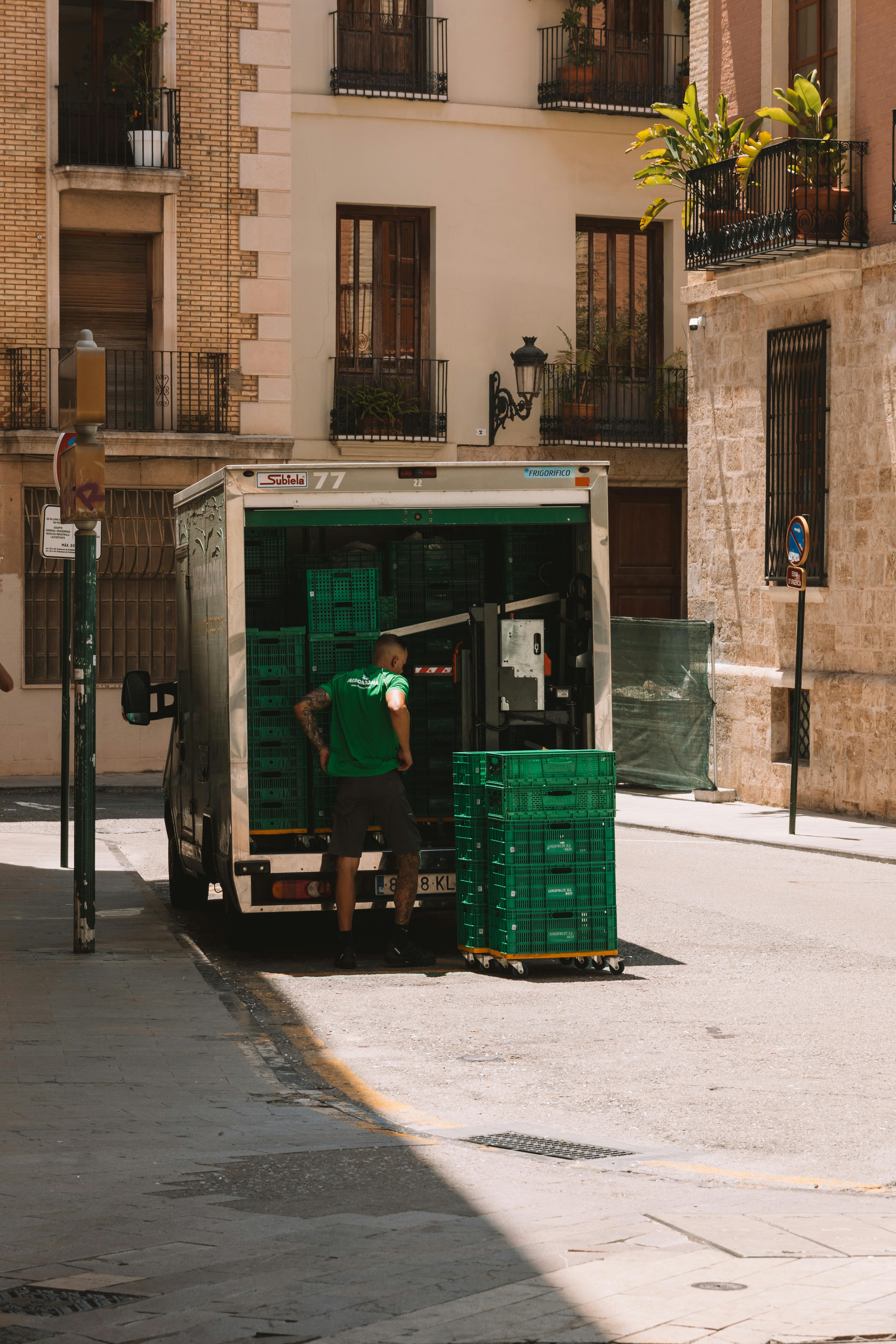 Man Loading Crates onto Delivery Truck · Free Stock Photo