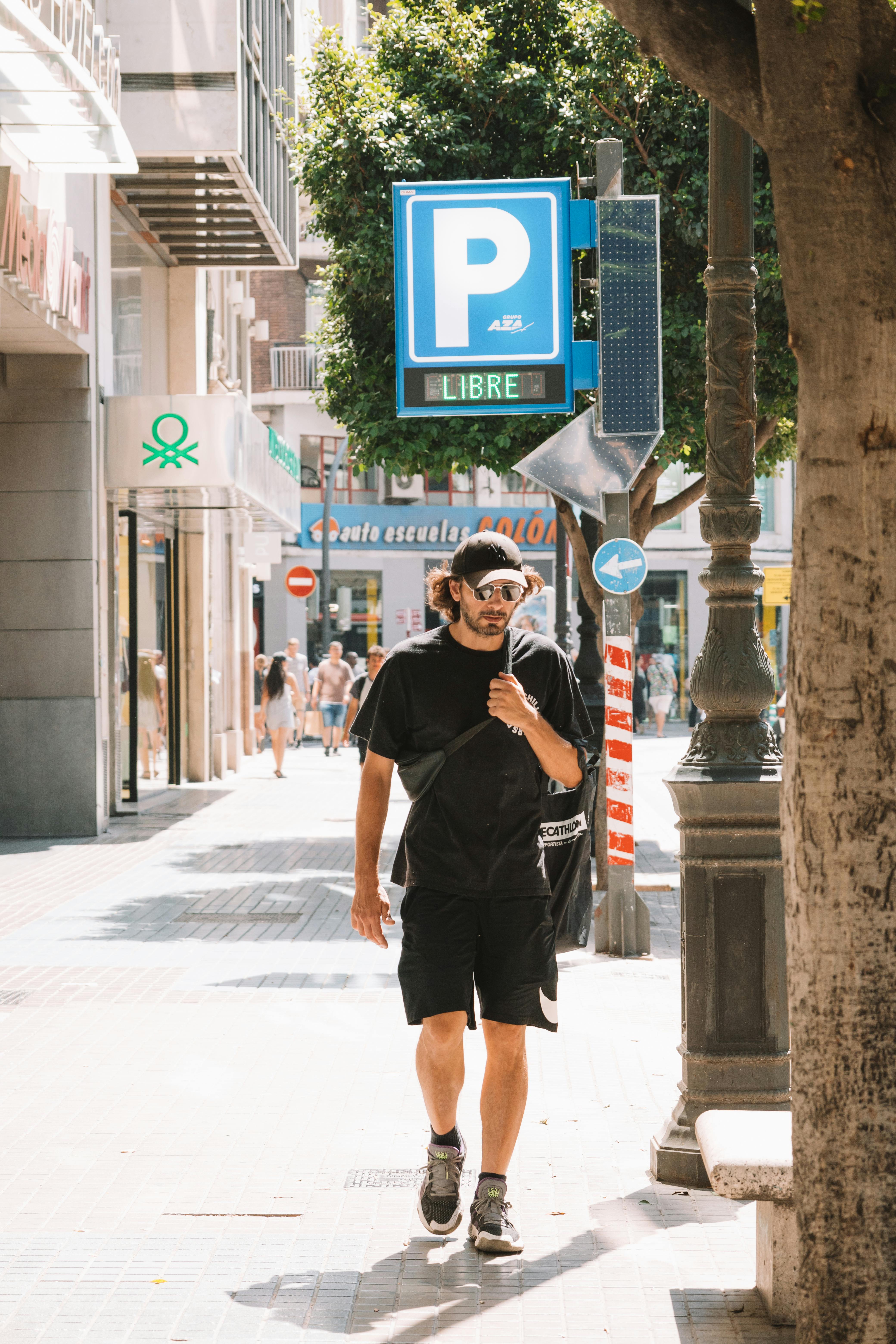 Man Walking on Sunlit Sidewalk · Free Stock Photo