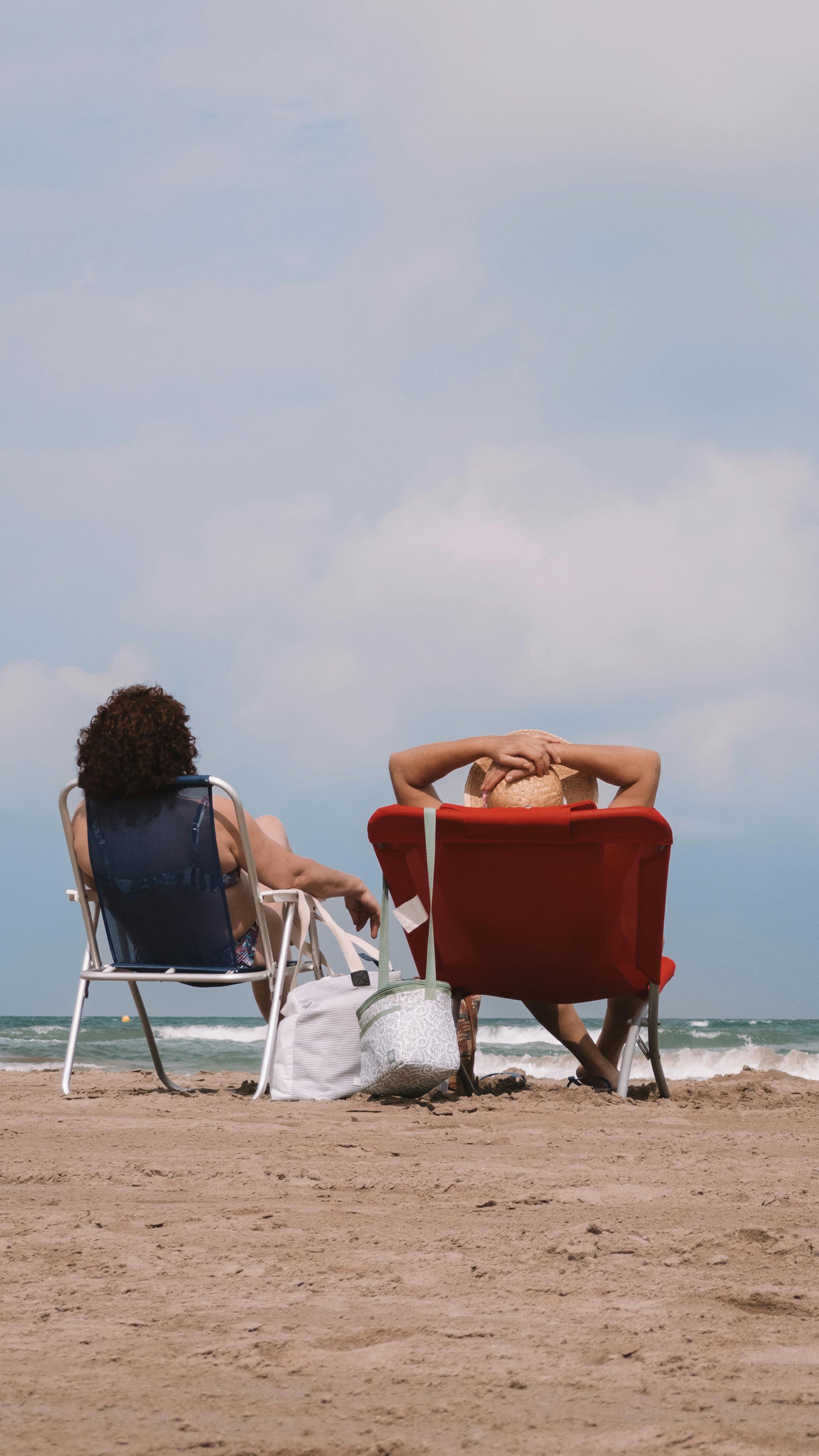 Back View of People on Sun Loungers on the Beach · Free Stock Photo