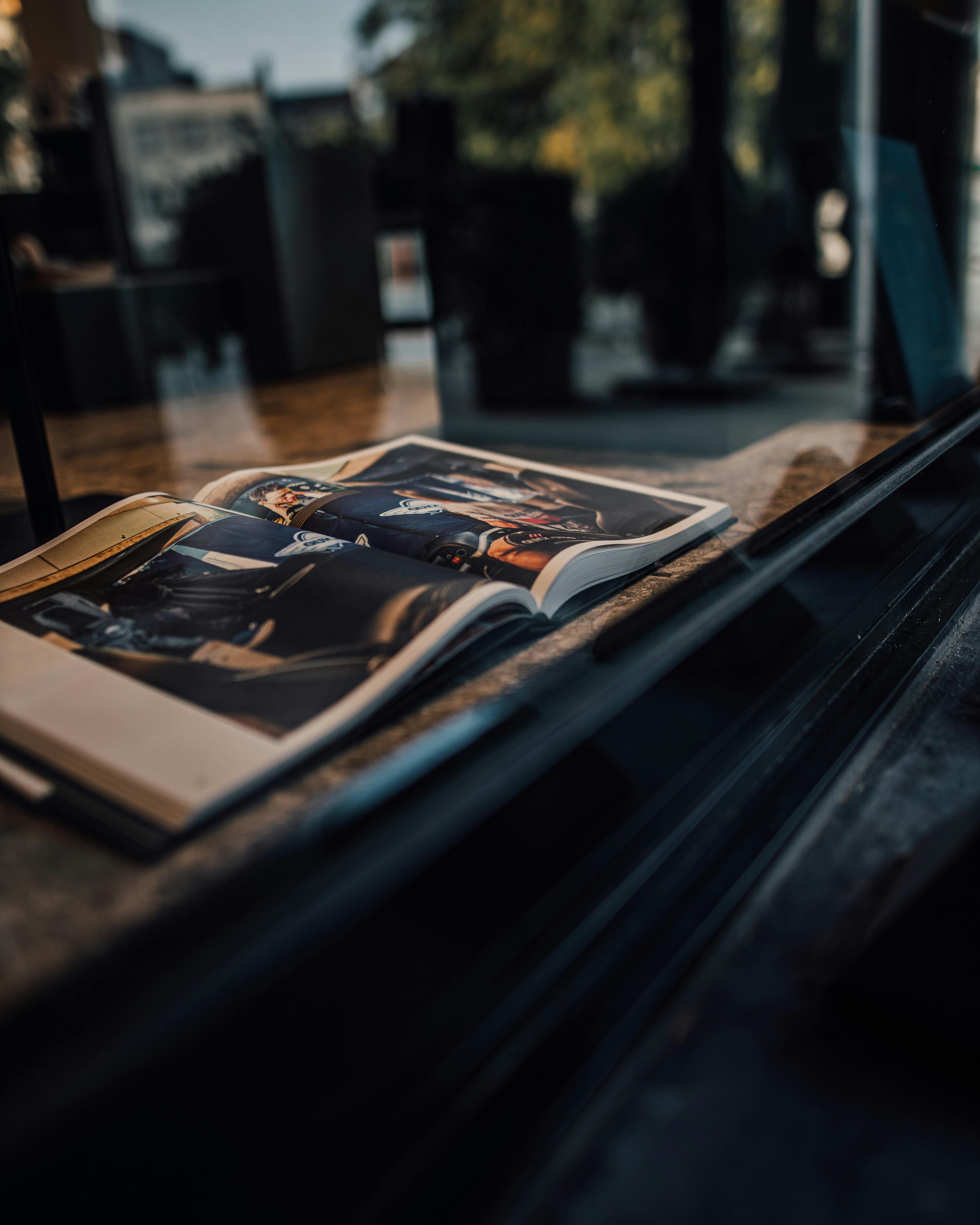 Open Art Book Lying Behind a Shop Window · Free Stock Photo